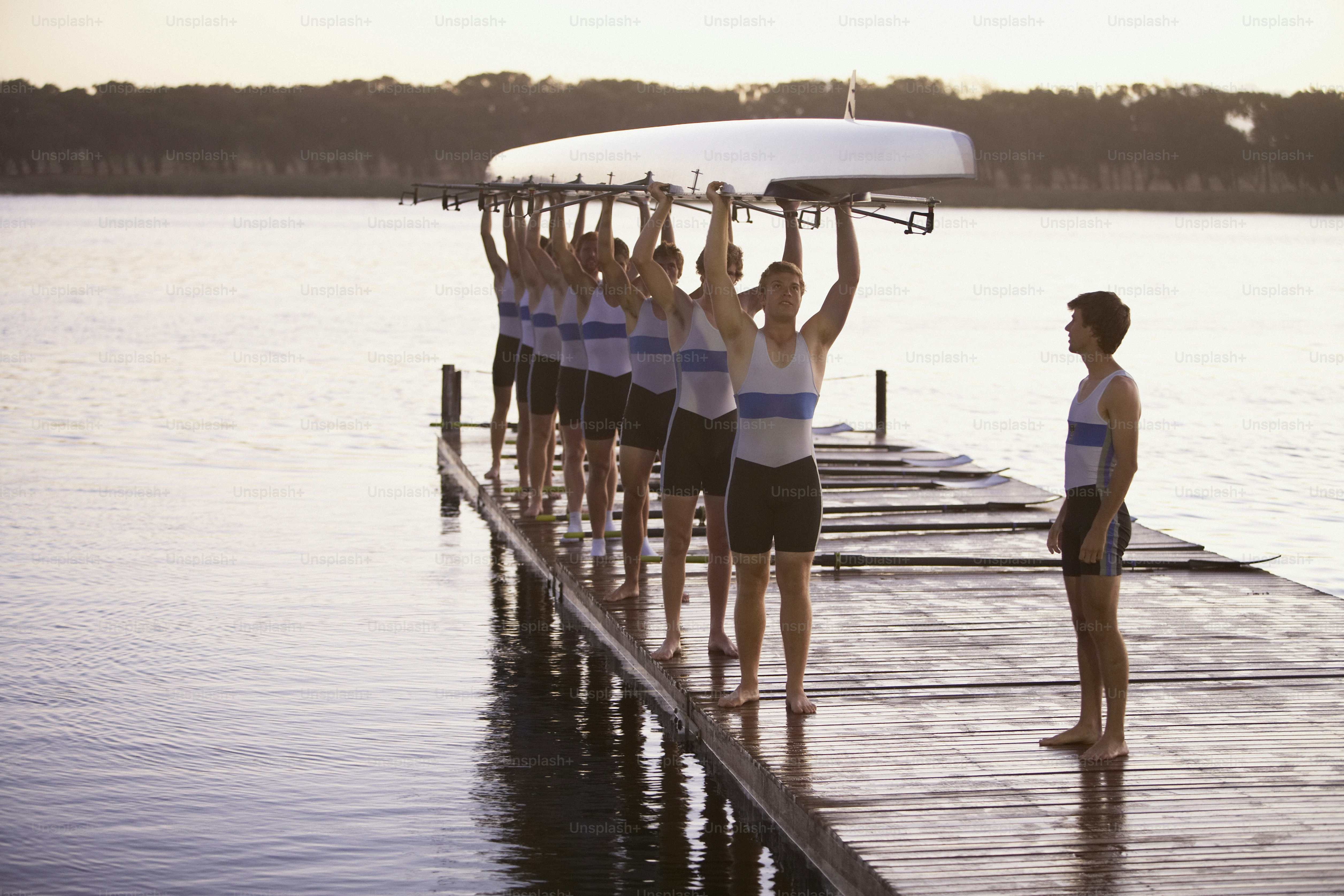Un groupe d’hommes debout au sommet d’une jetée photo – Aviron Photo ...