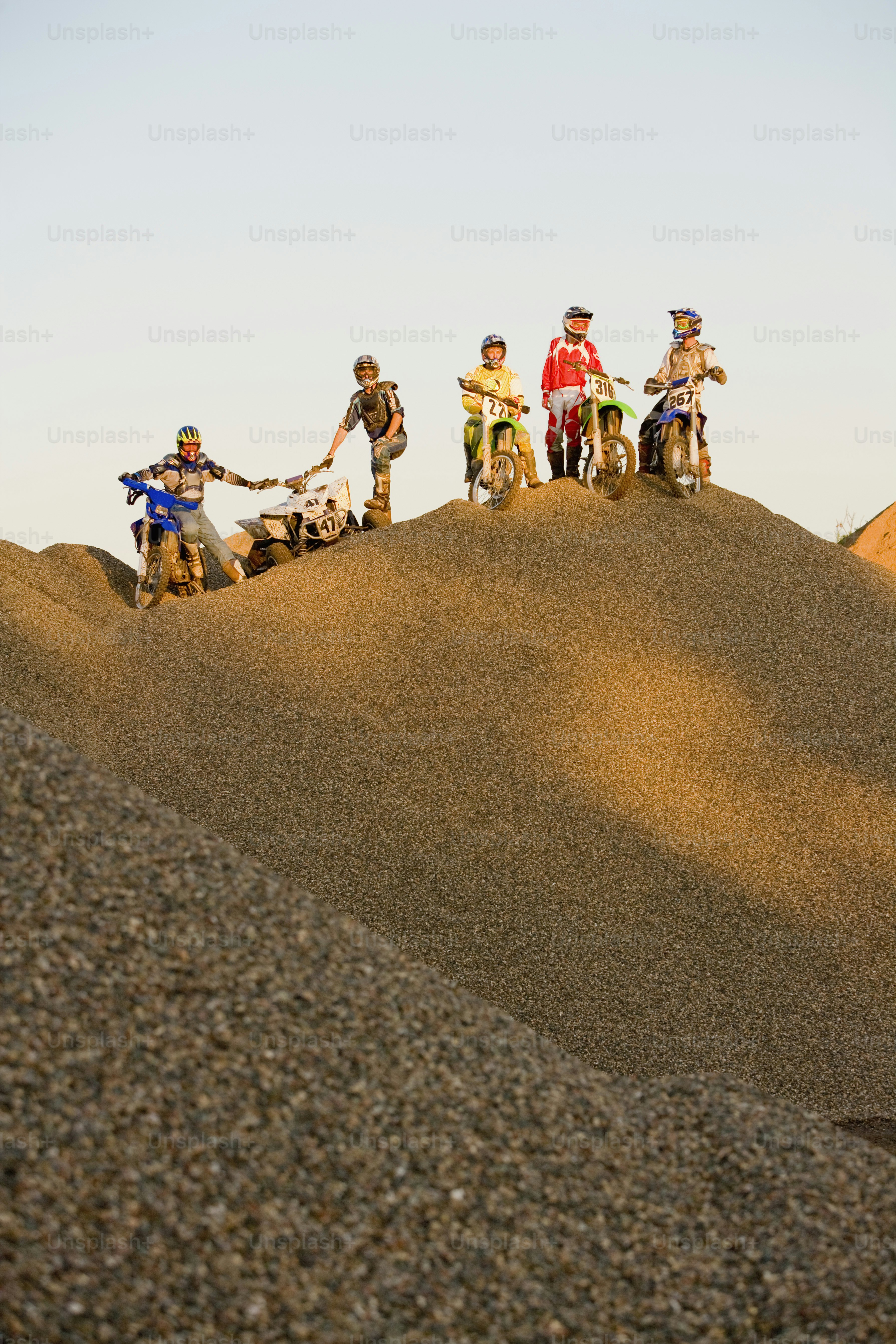 A group of people riding dirt bikes on a dirt road photo – Motocross ...