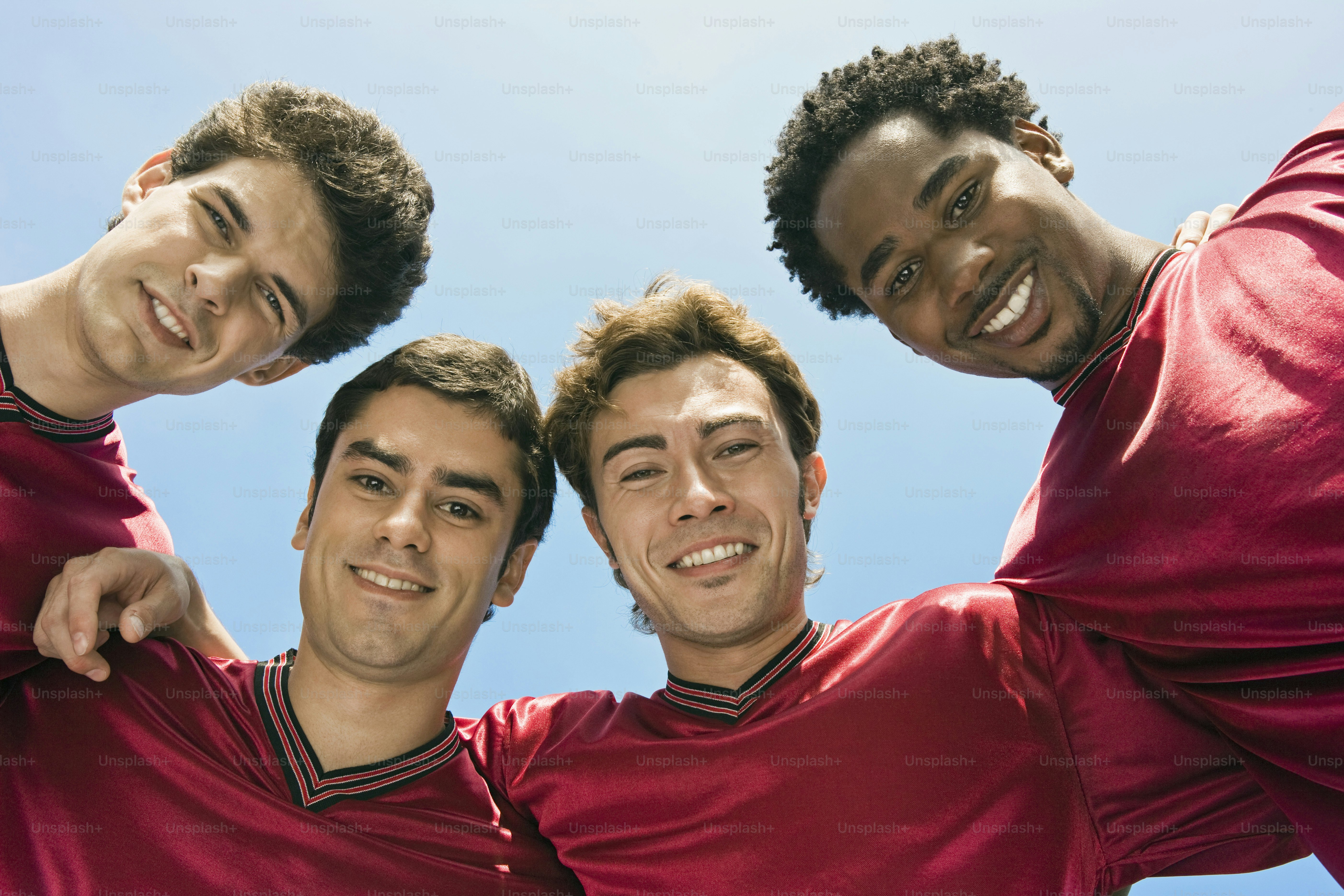 A group of three men standing next to each other photo – People Image ...