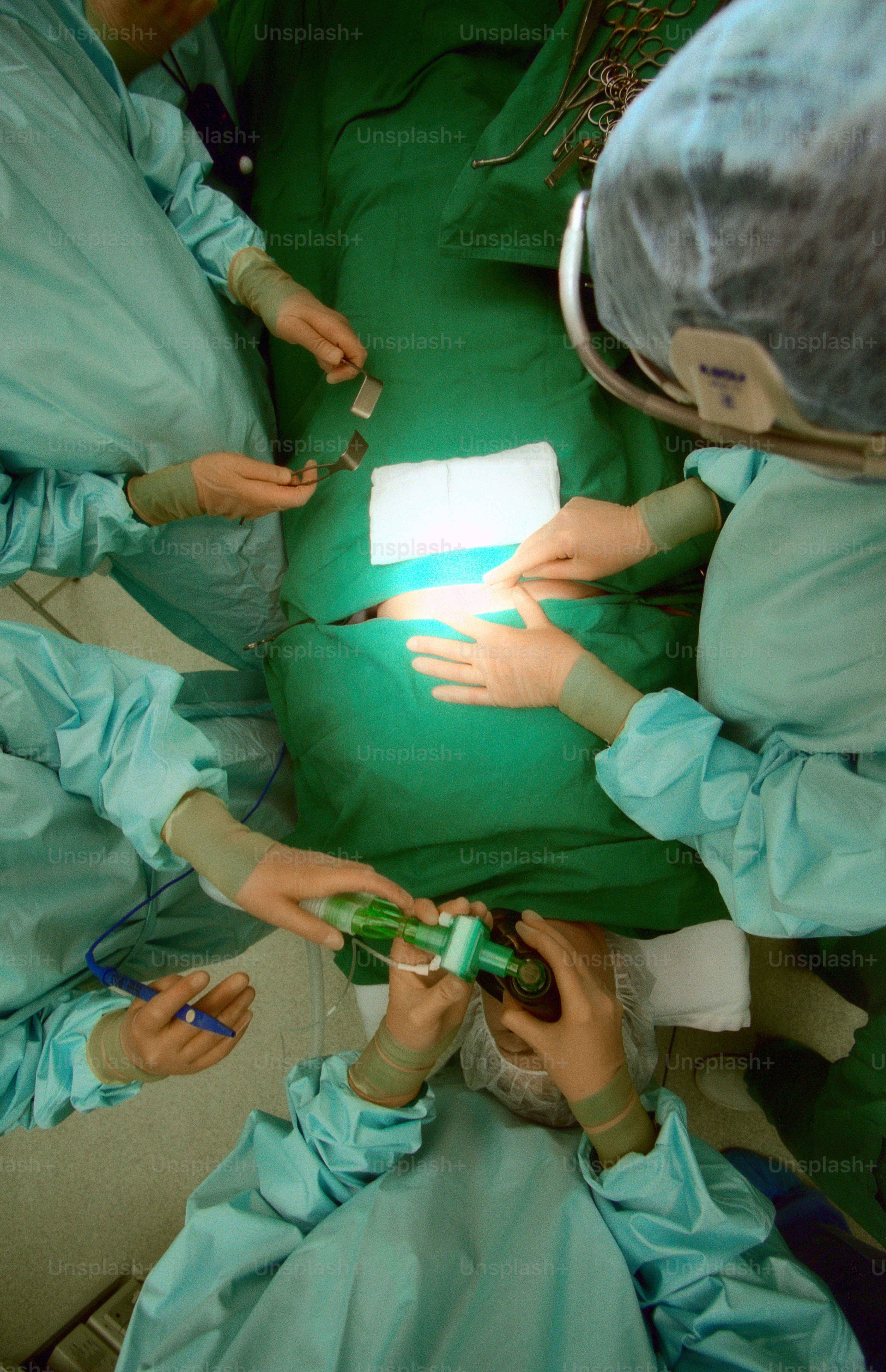 A group of doctors performing surgery on a patient photo – Togetherness ...
