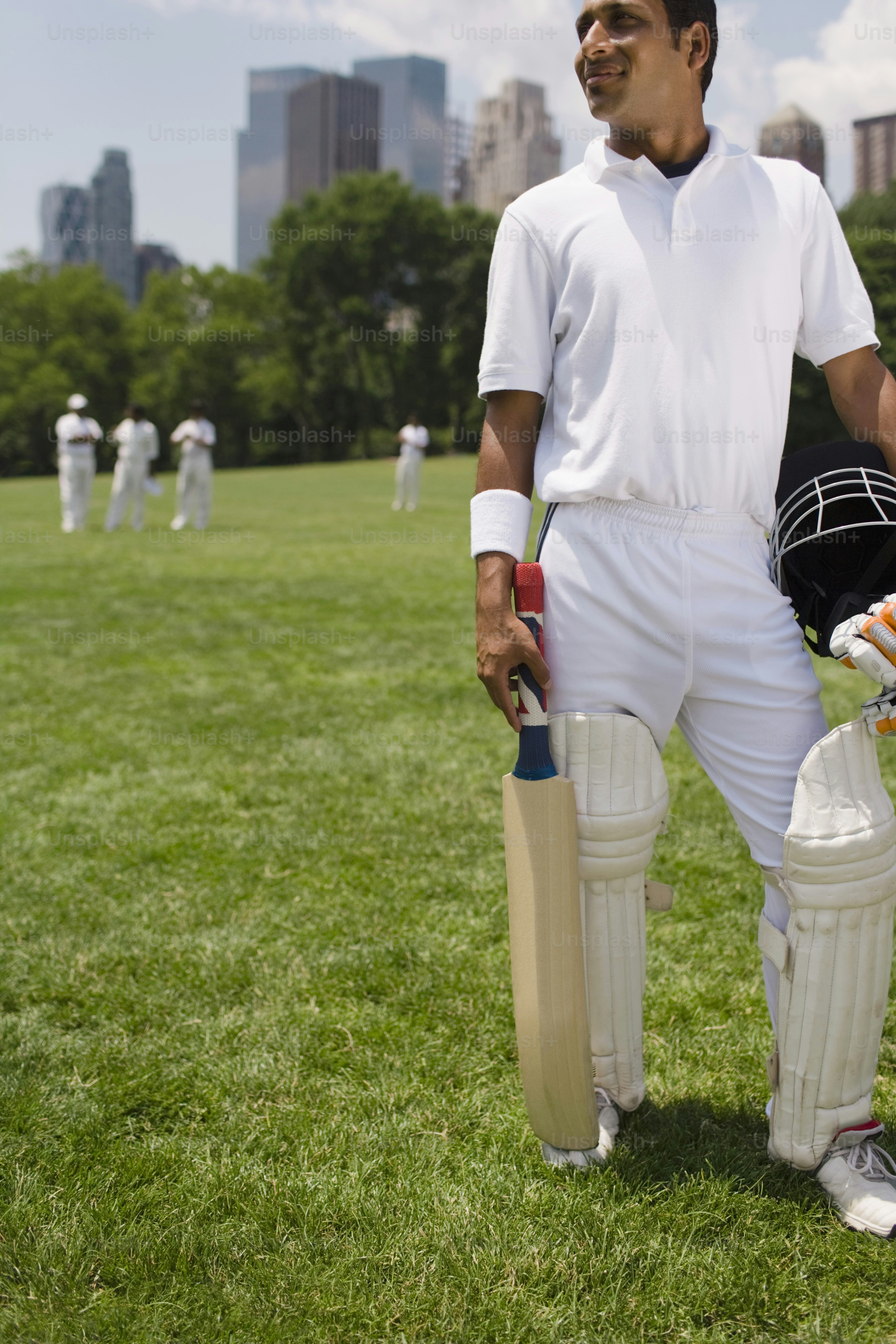 A man holding a cricket bat and a helmet photo – Cricket player Image ...