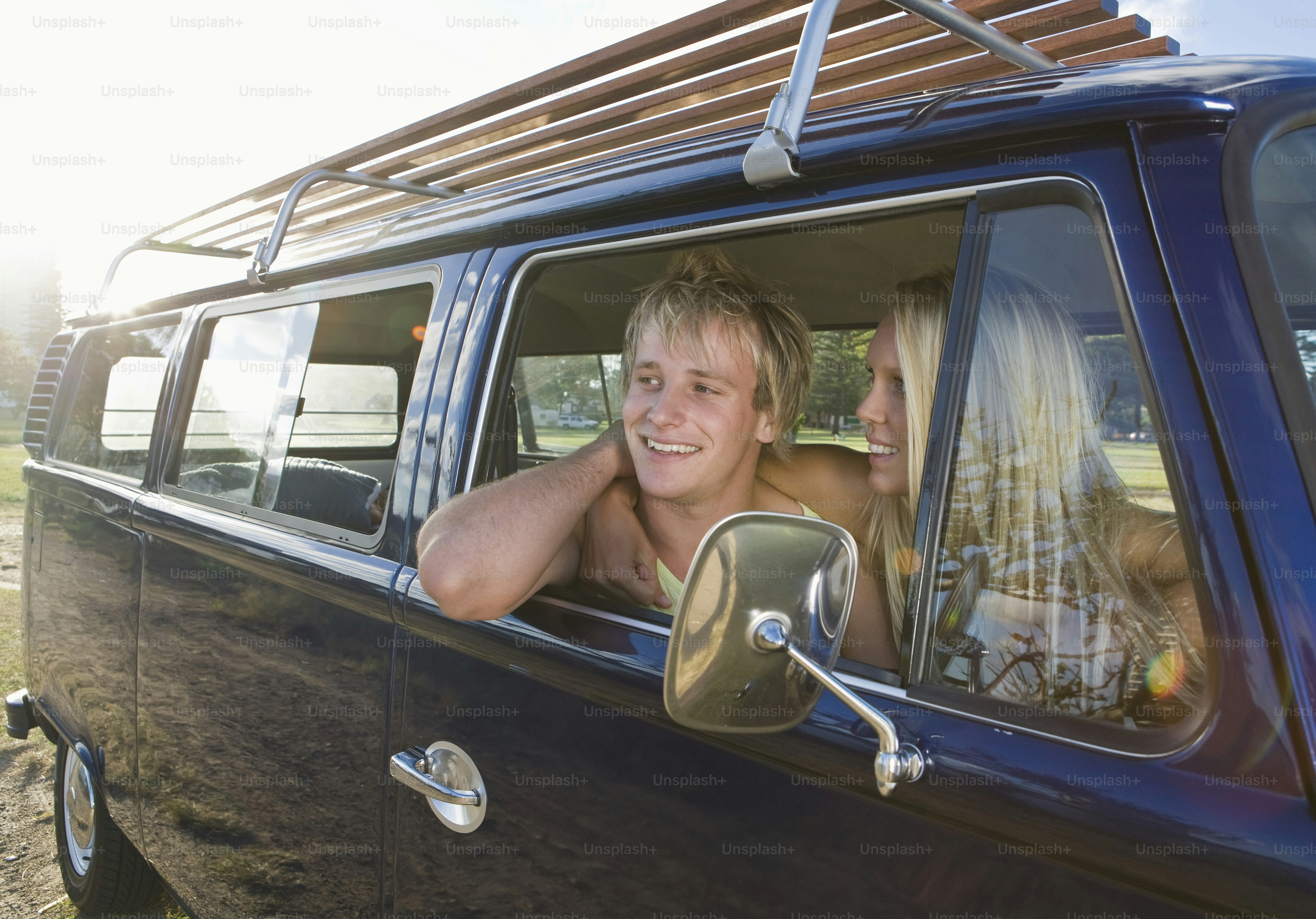 A man and a woman sitting in the back of a truck photo – Minibus Image ...