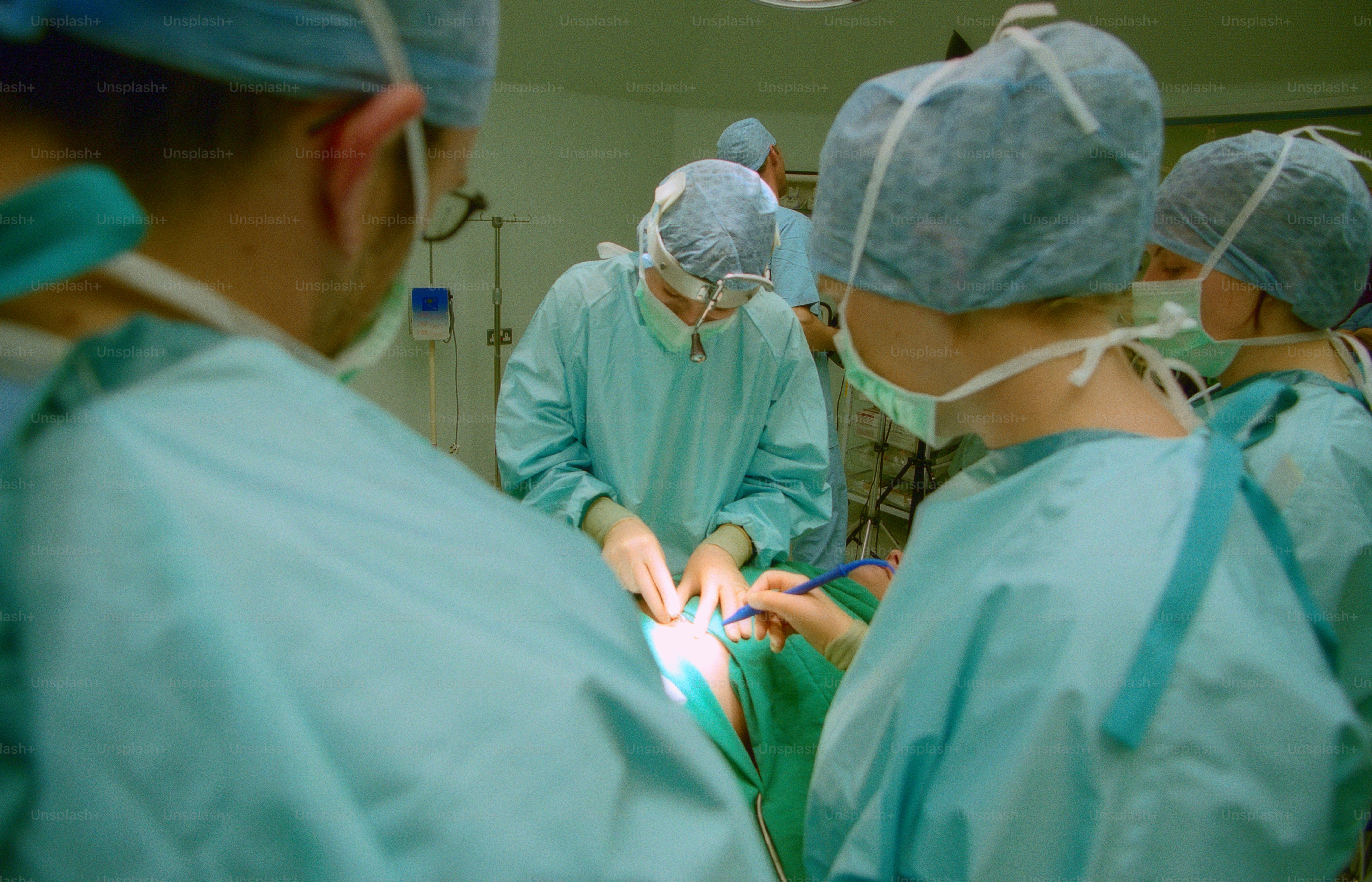 A group of doctors performing surgery in a hospital photo – Doctor ...
