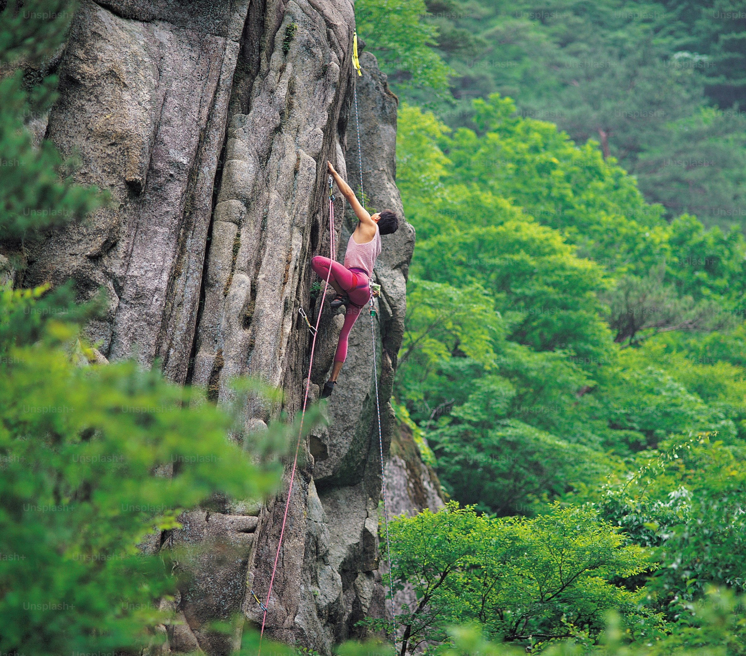 A man climbing up the side of a mountain photo – Healthy lifestyle ...