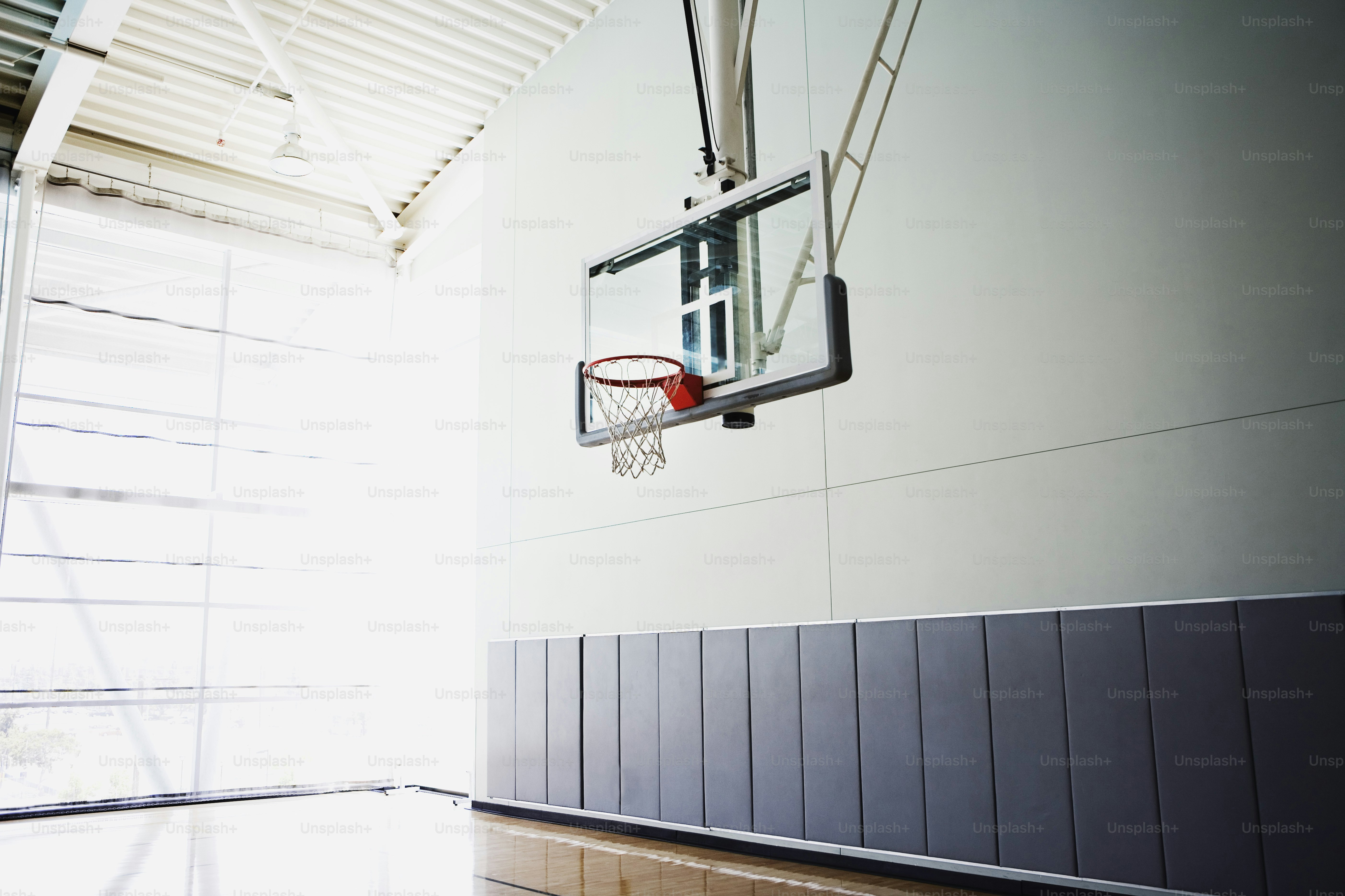 A basketball hoop hanging from the side of a basketball court photo ...