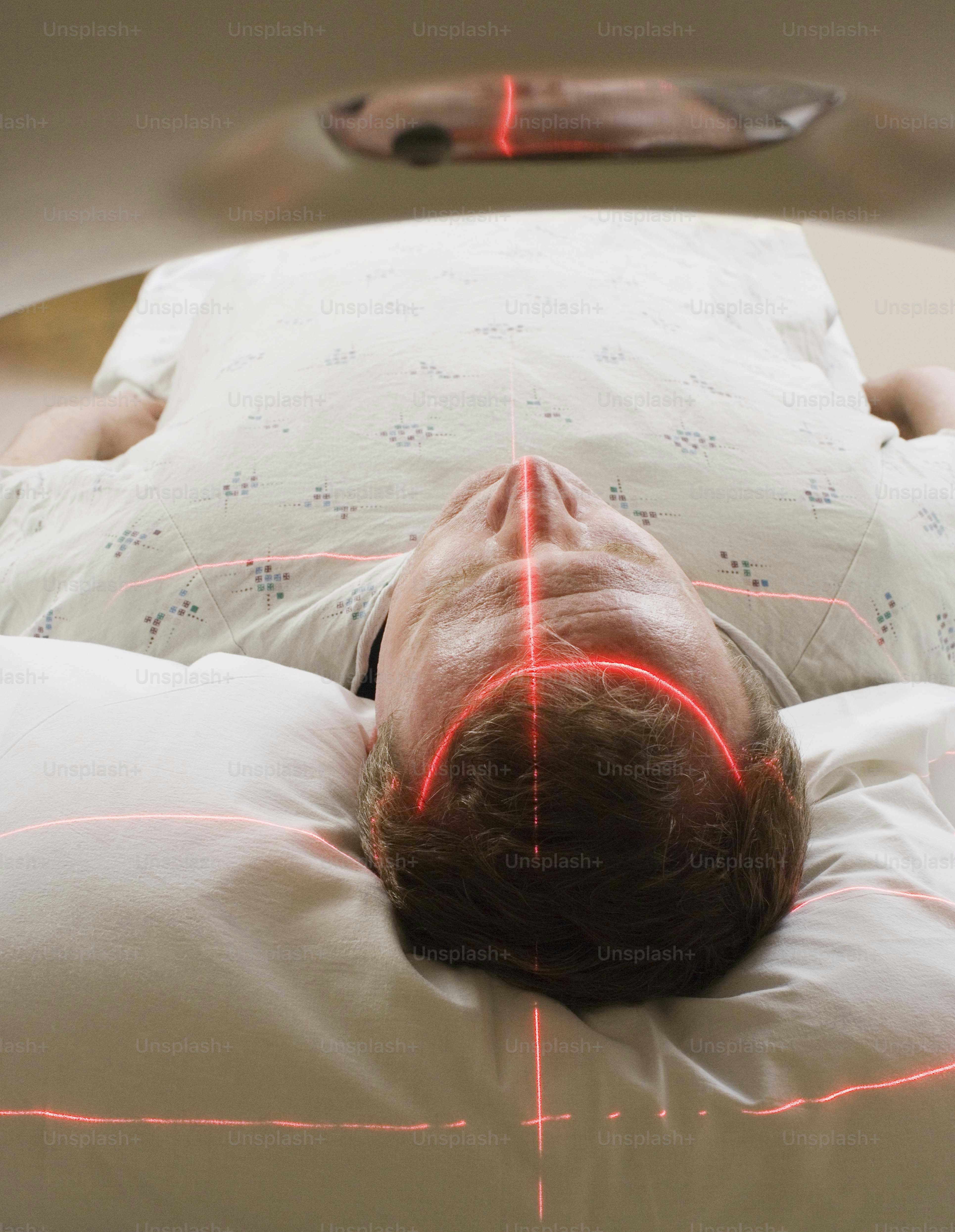 A man laying in bed with his head on a pillow photo – Mri scan Image on ...