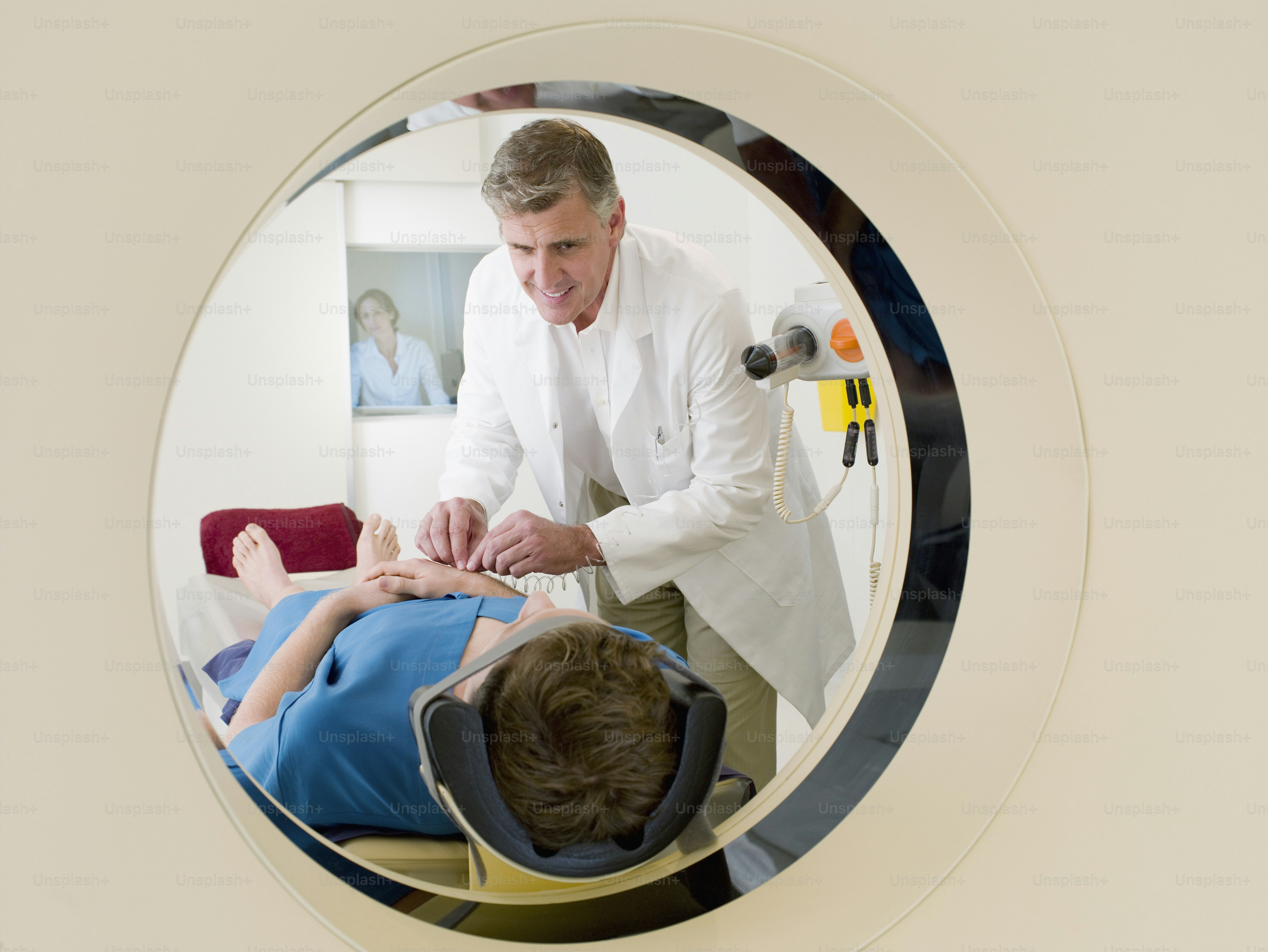 A man in a white lab coat getting a procedure on a young boy photo ...
