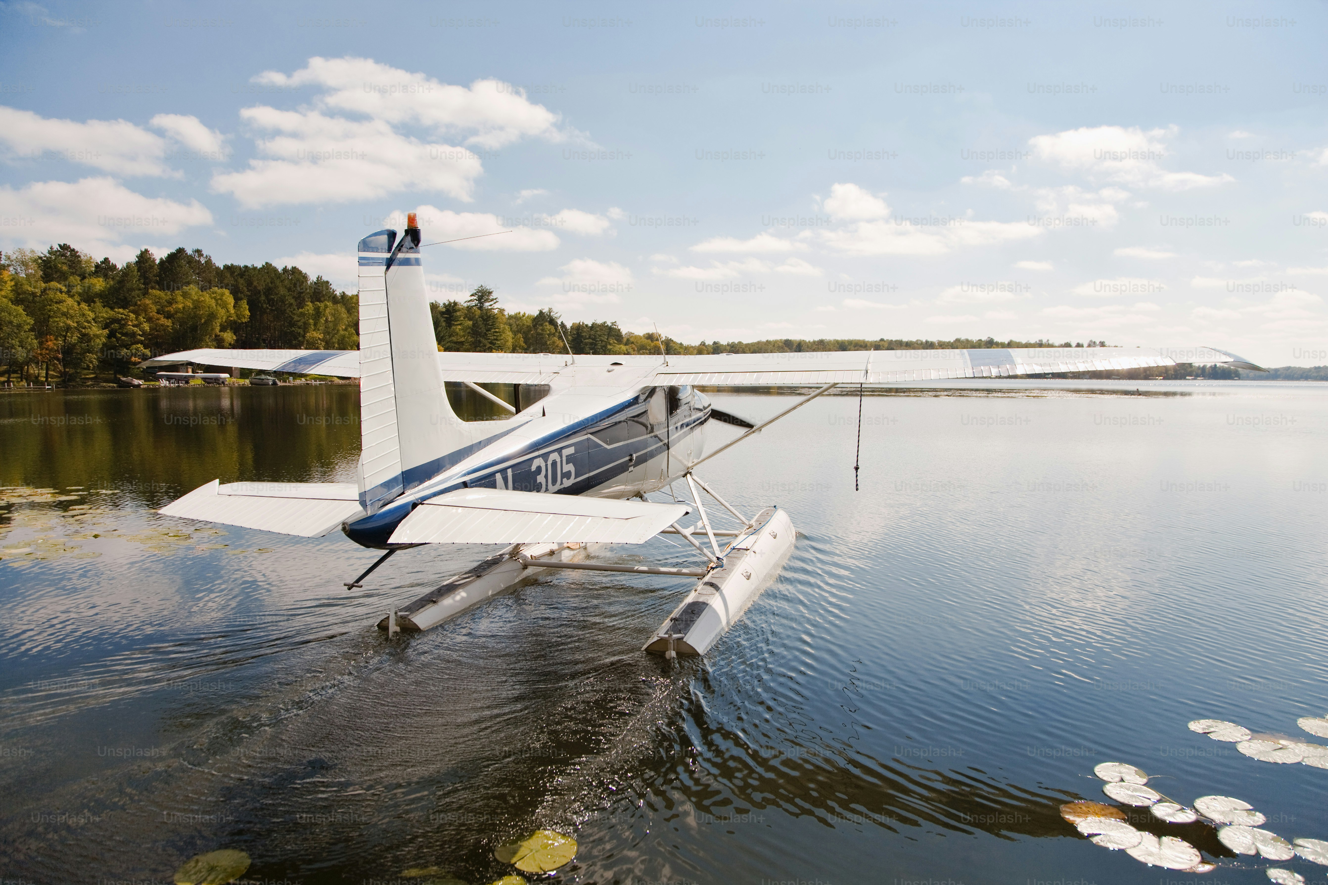 A small plane sitting on top of a body of water photo – Seaplane Image ...