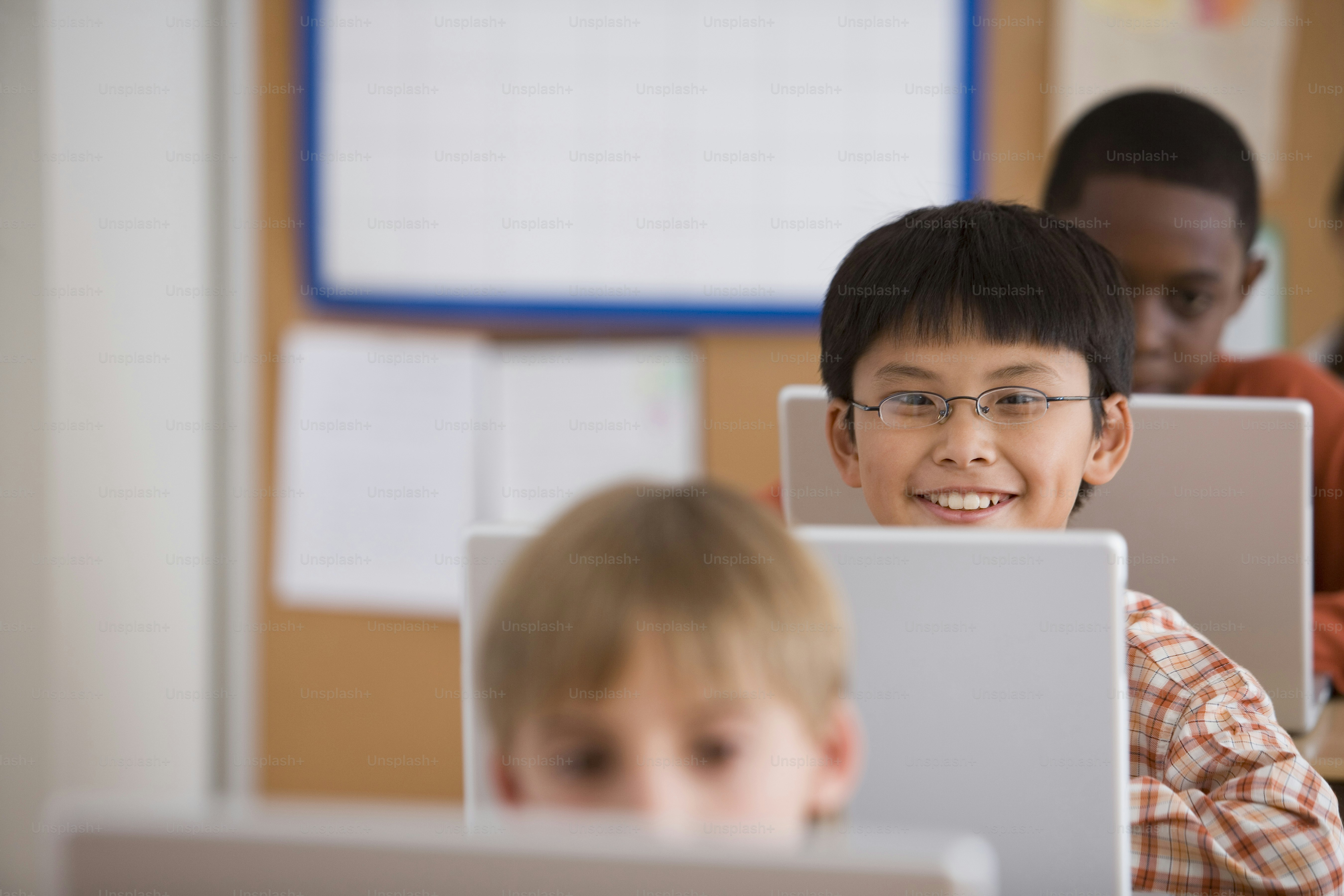 A group of children sitting in front of laptop computers photo ...