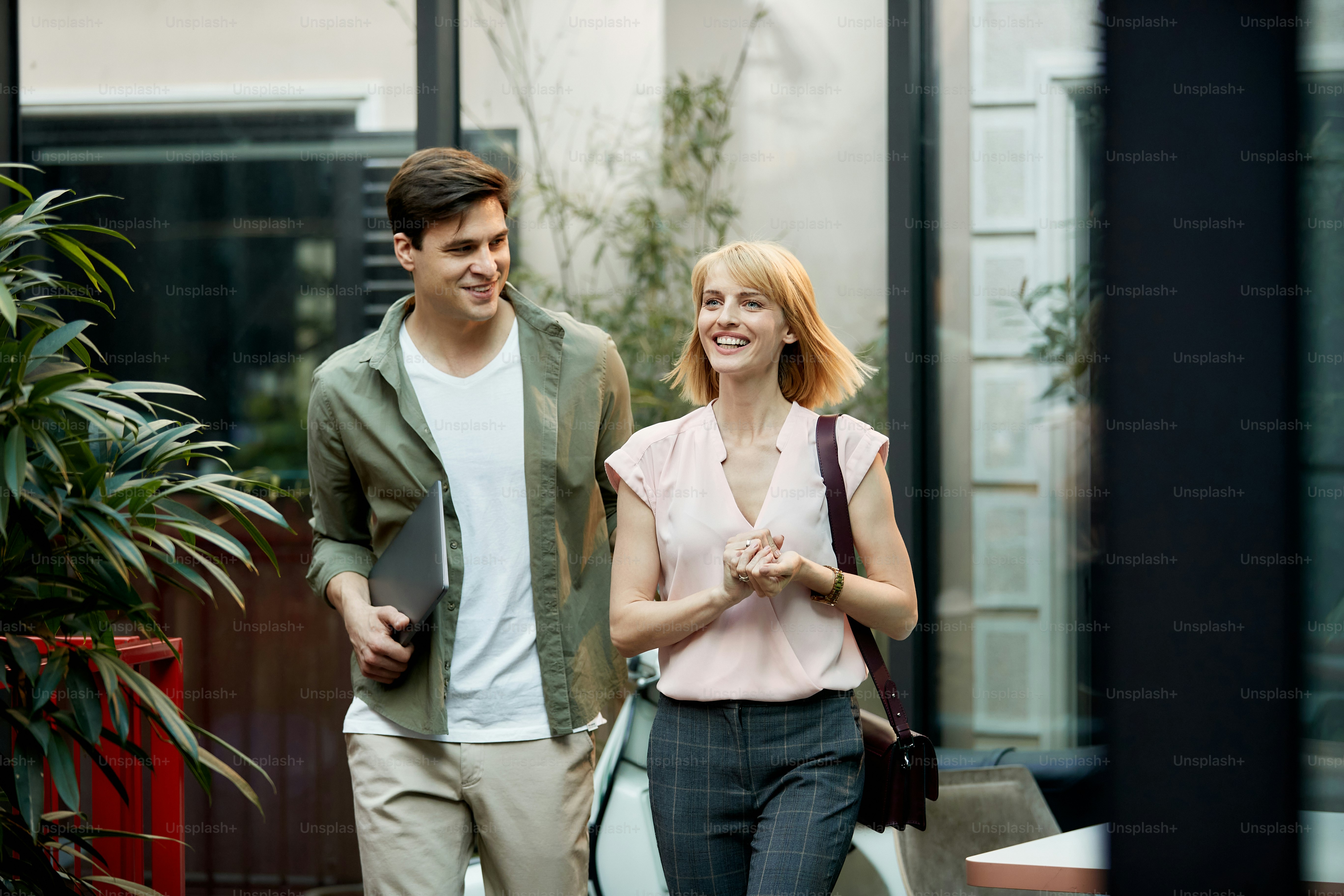 Happy businesswoman and her male colleague walking on the street. photo ...