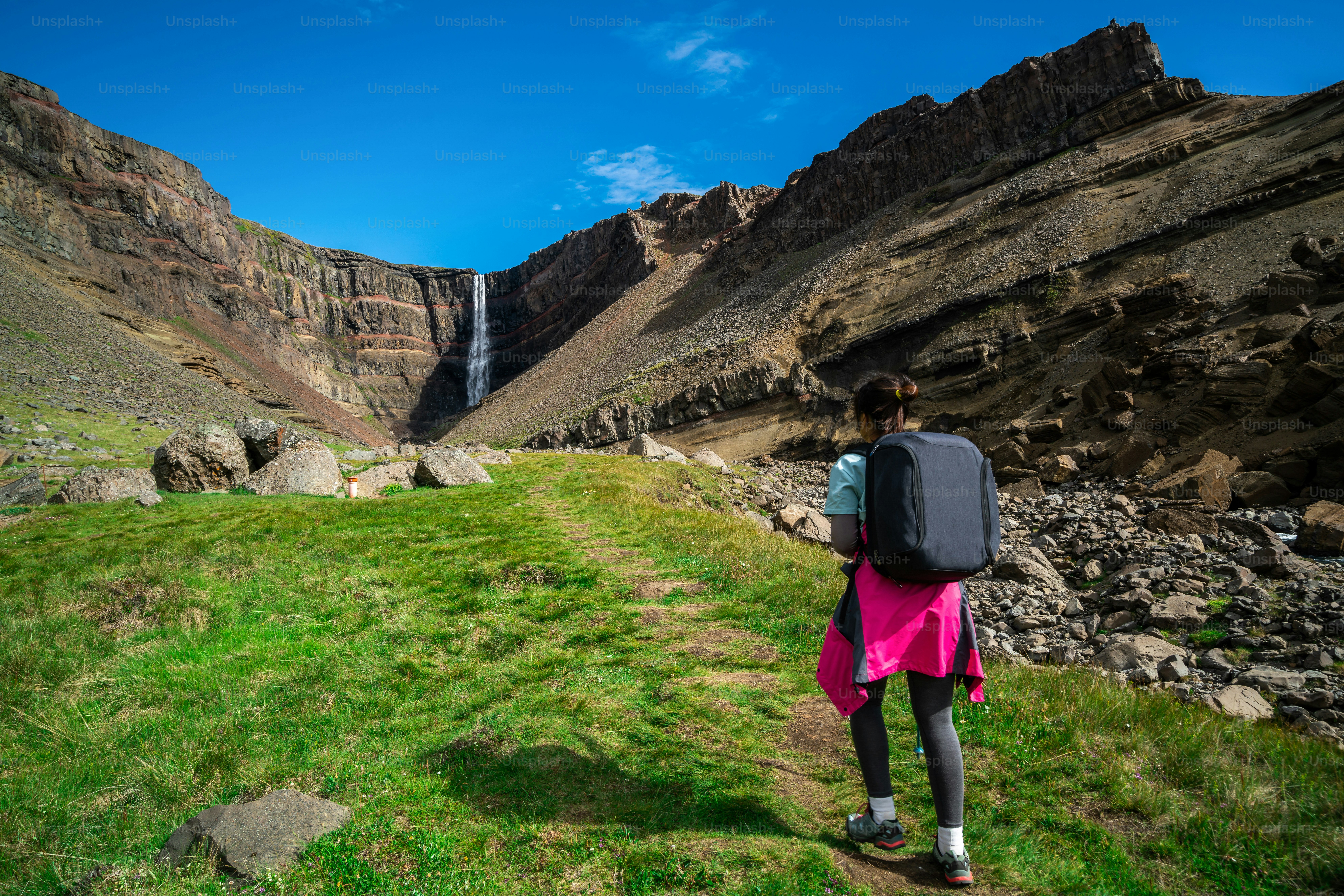 Femme voyageuse trekking dans le paysage estival islandais à la cascade ...
