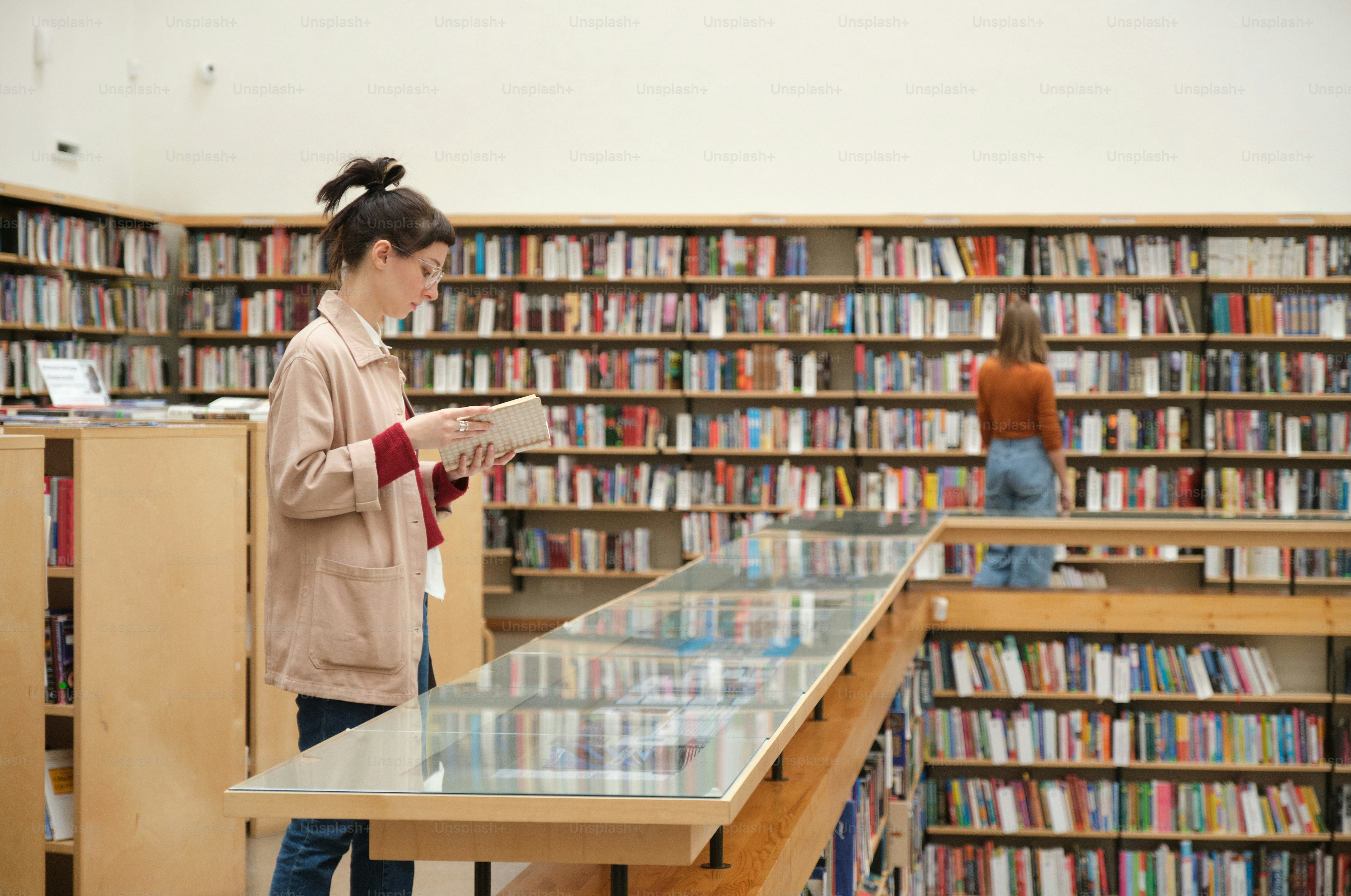 Young people studying in the library and choosing books for reading 사진 ...