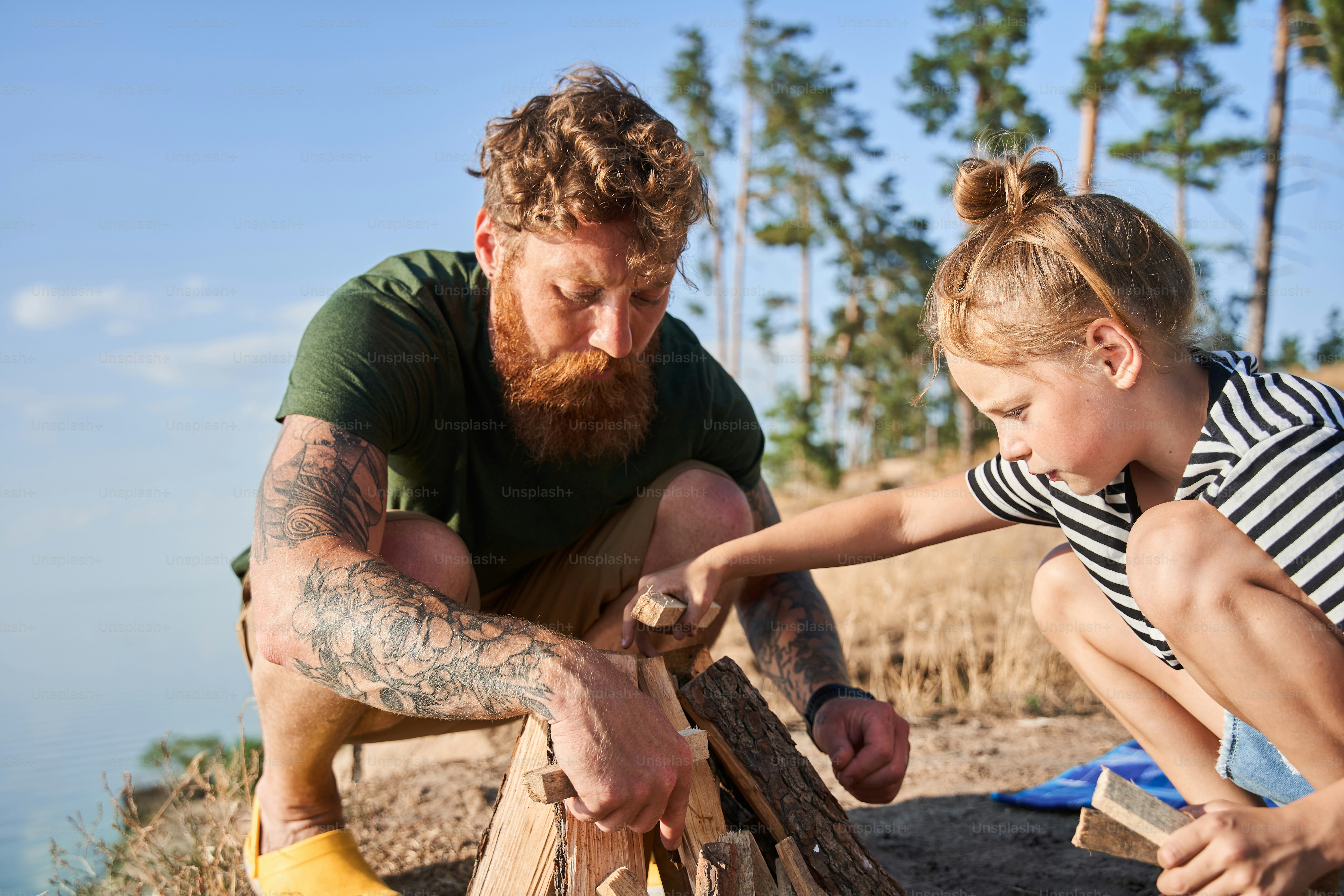 Incredible adventure. Little cute daughter holding firewood near the ...