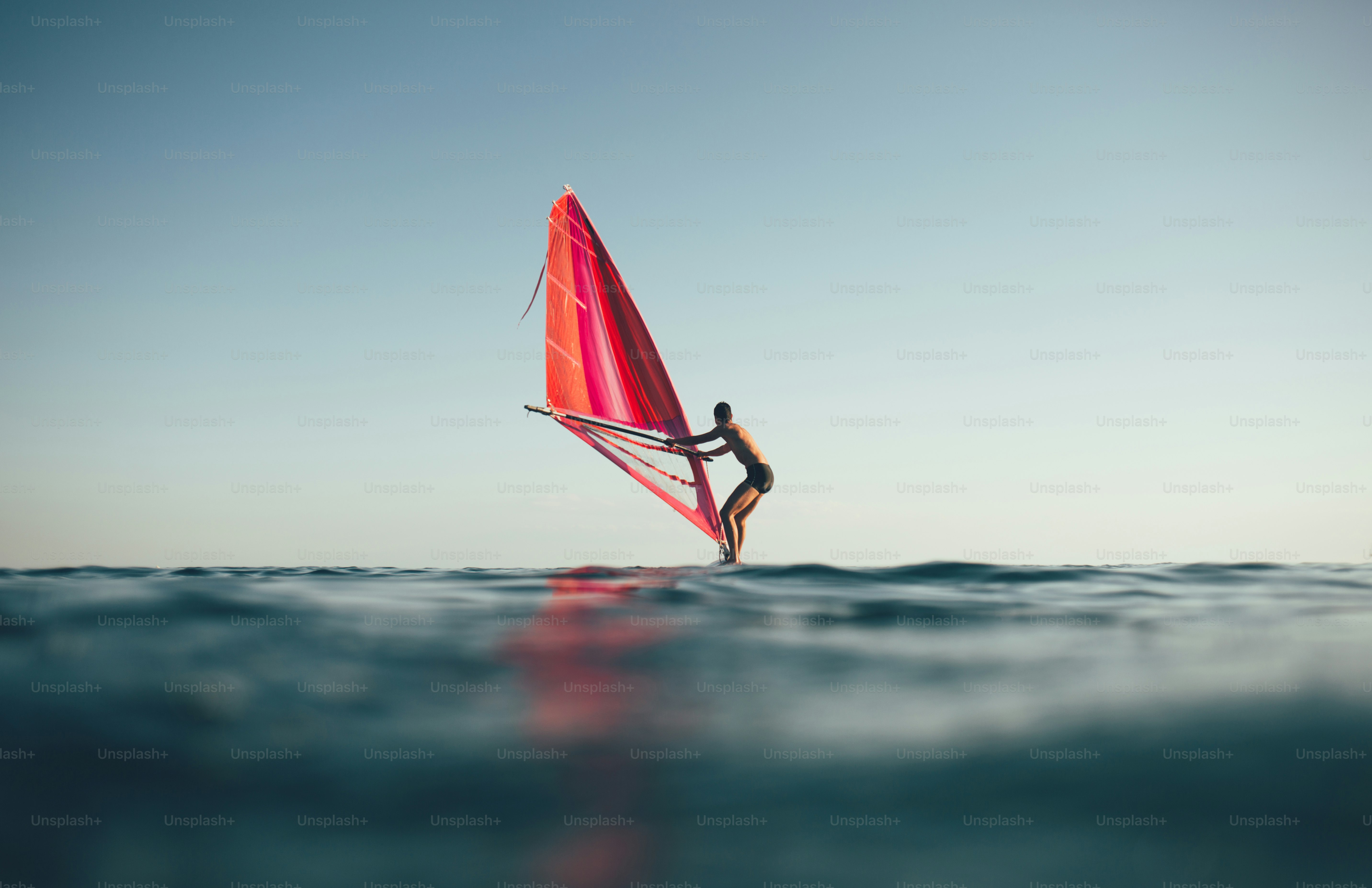 Low angle view of surfer silhouette balancing on windsurf board. photo – Windsurf Image on Unsplash