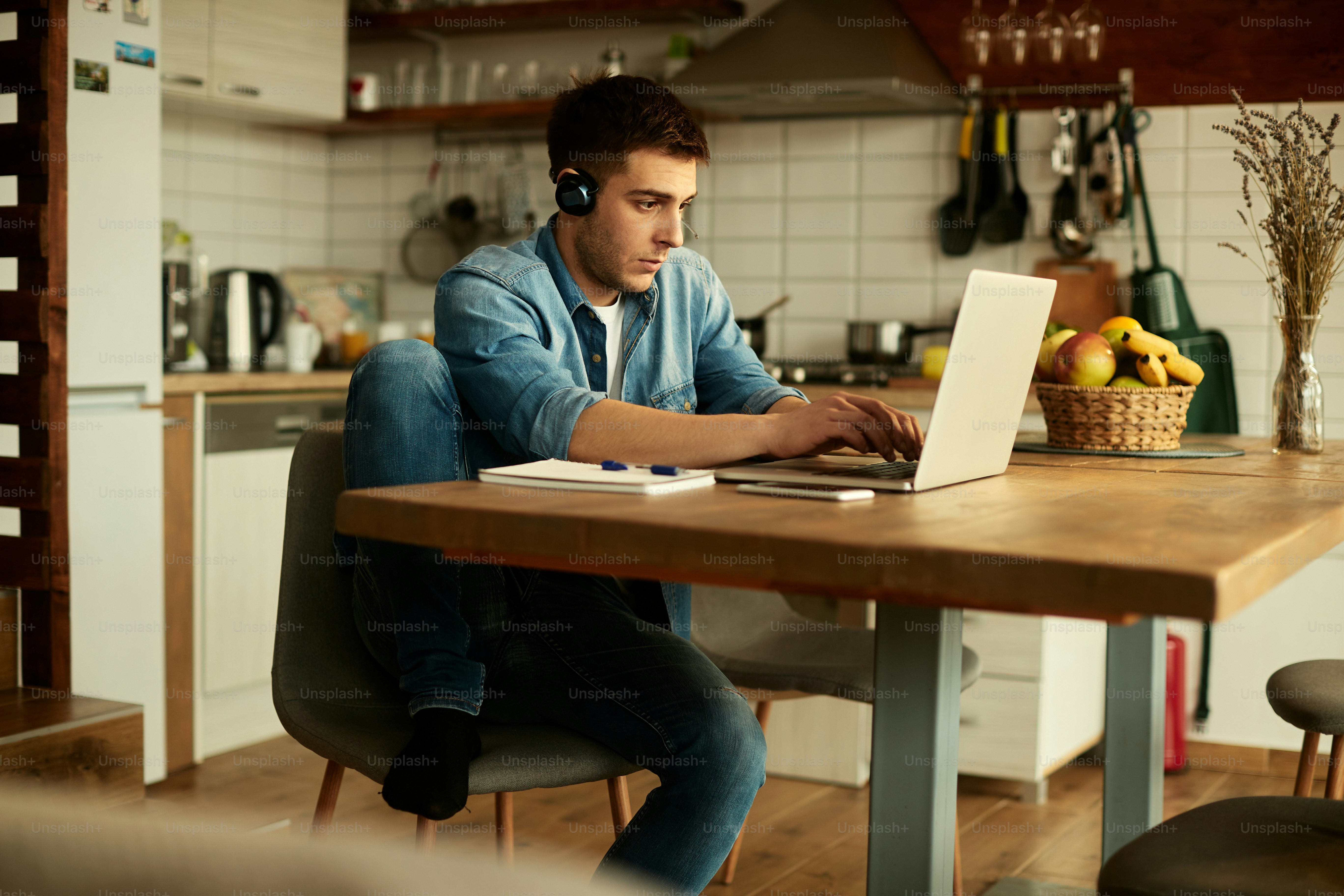 Freelance worker wearing headset and working on a computer at home ...