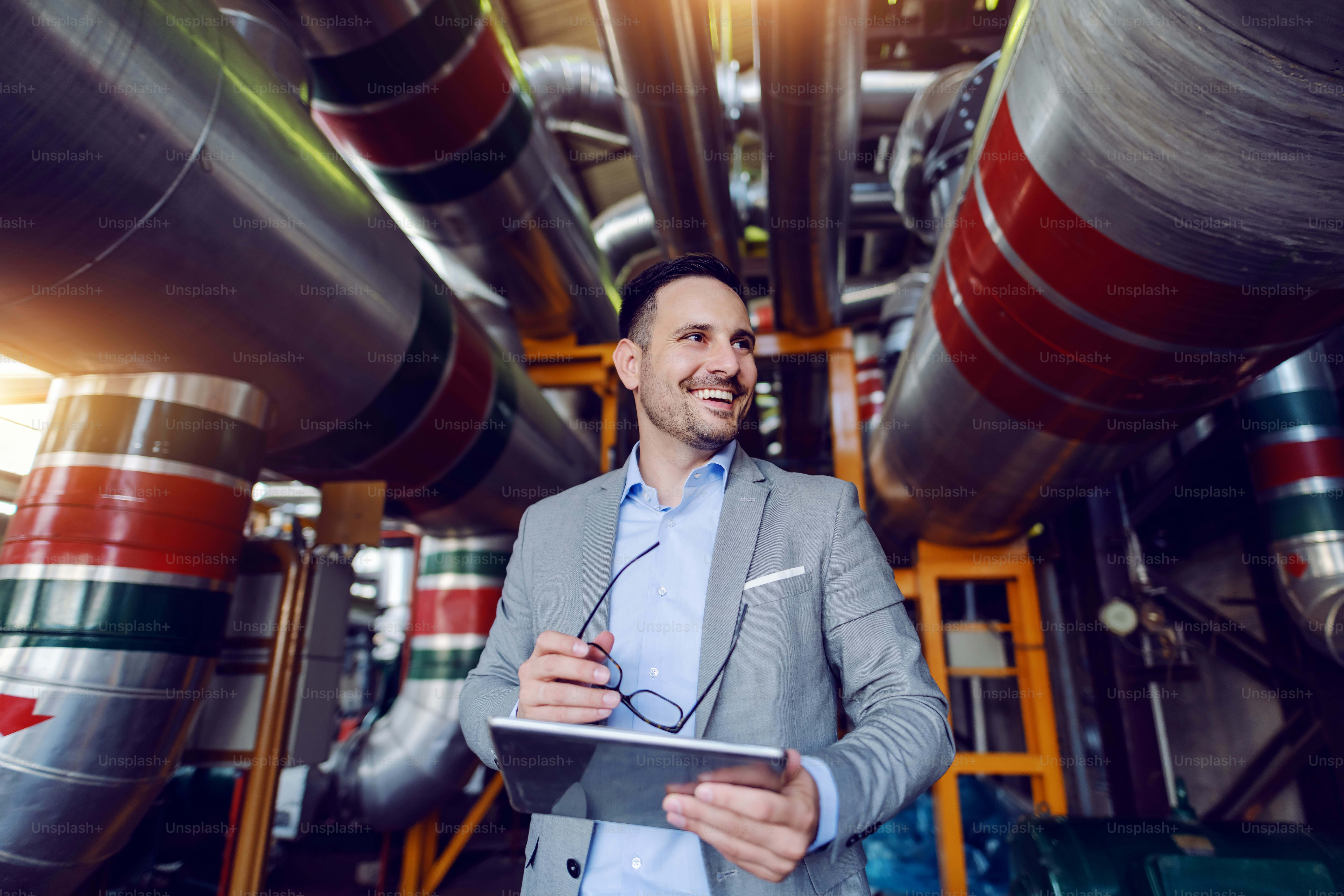 Foto Supervisor caucásico sonriente en traje gris sosteniendo una ...