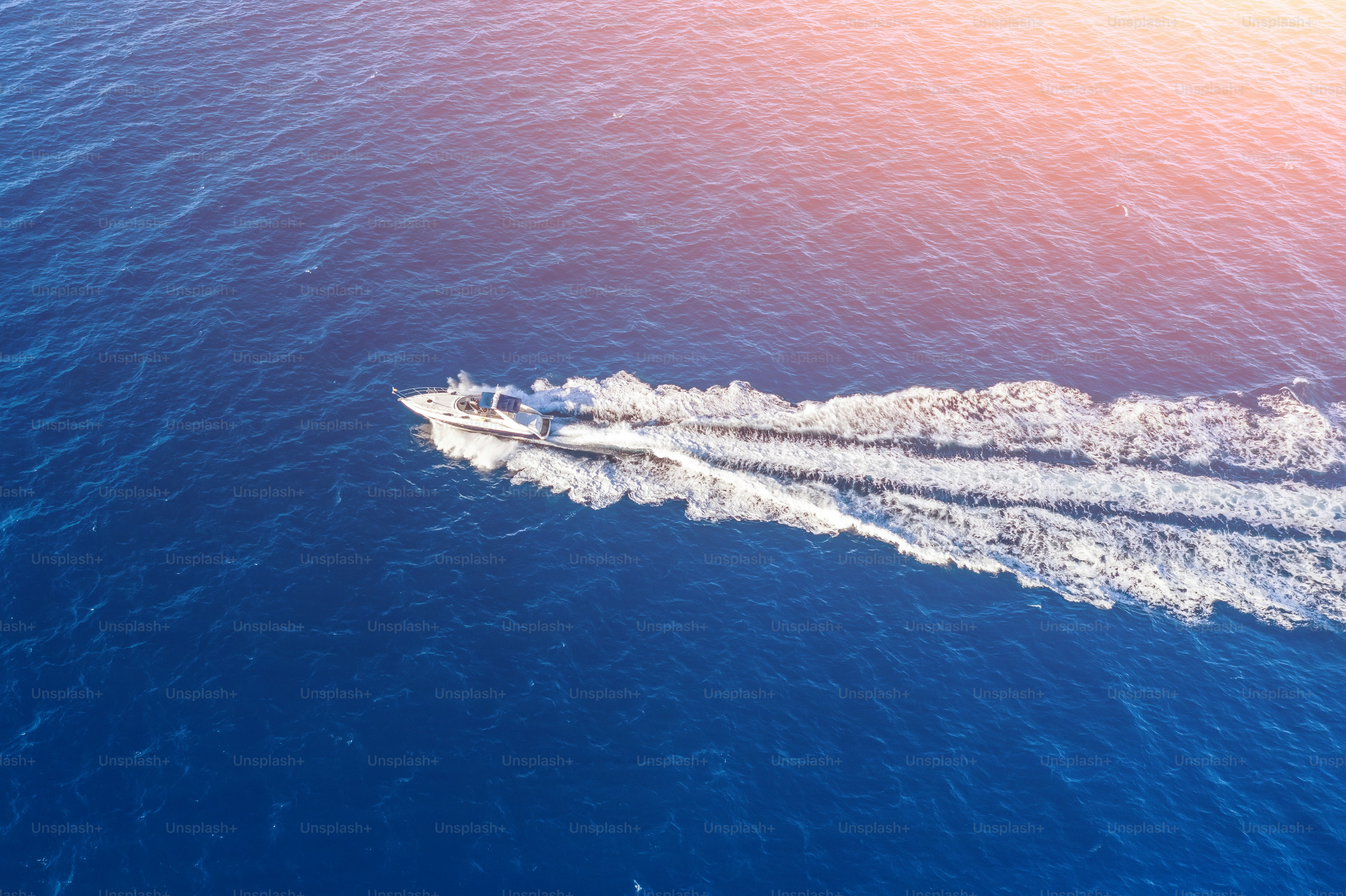 Boat launch at high speed floats to sunlight in the ocrean, aerial top ...