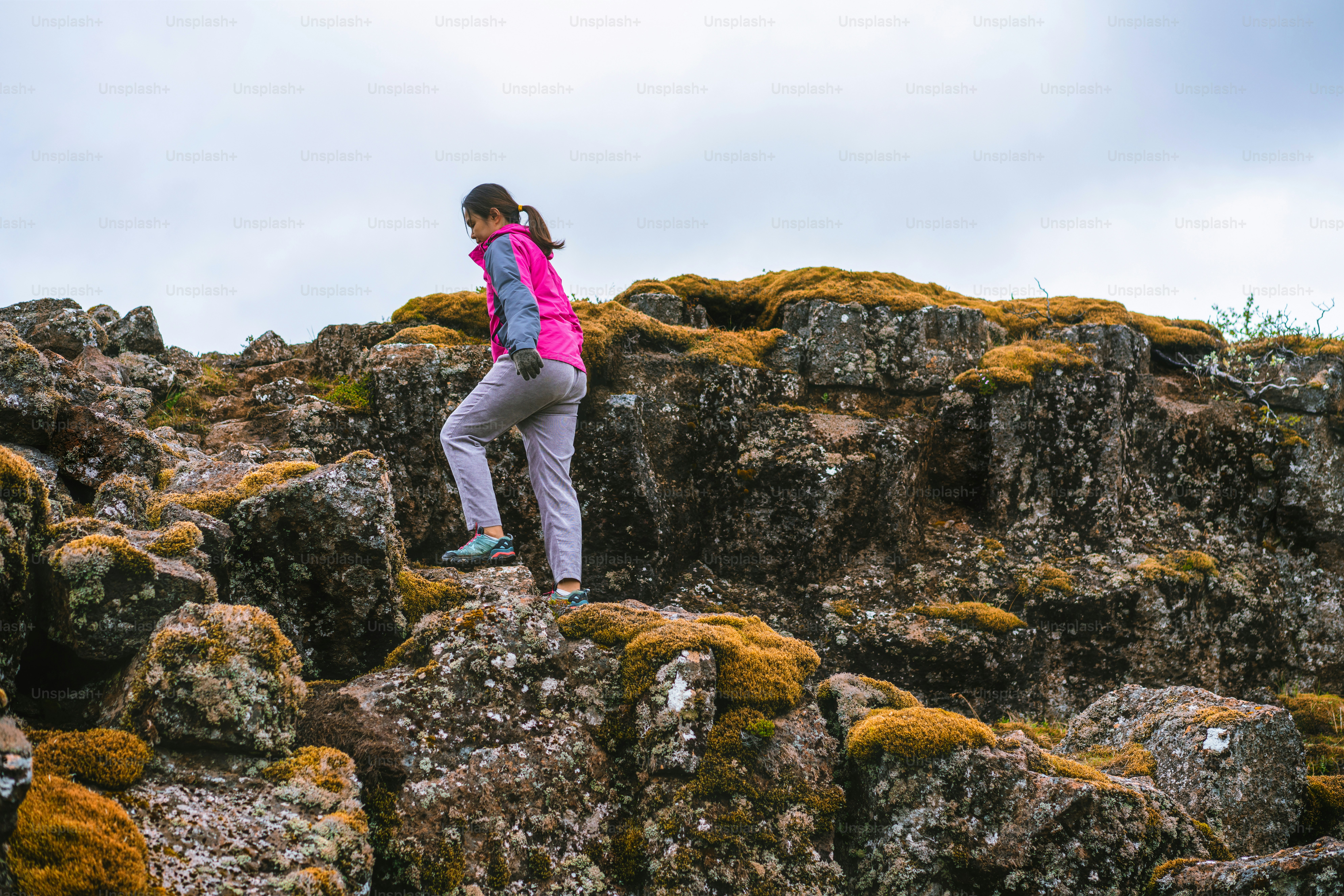 Woman traveler and explorer travels in the Icelandic landscape hiking ...