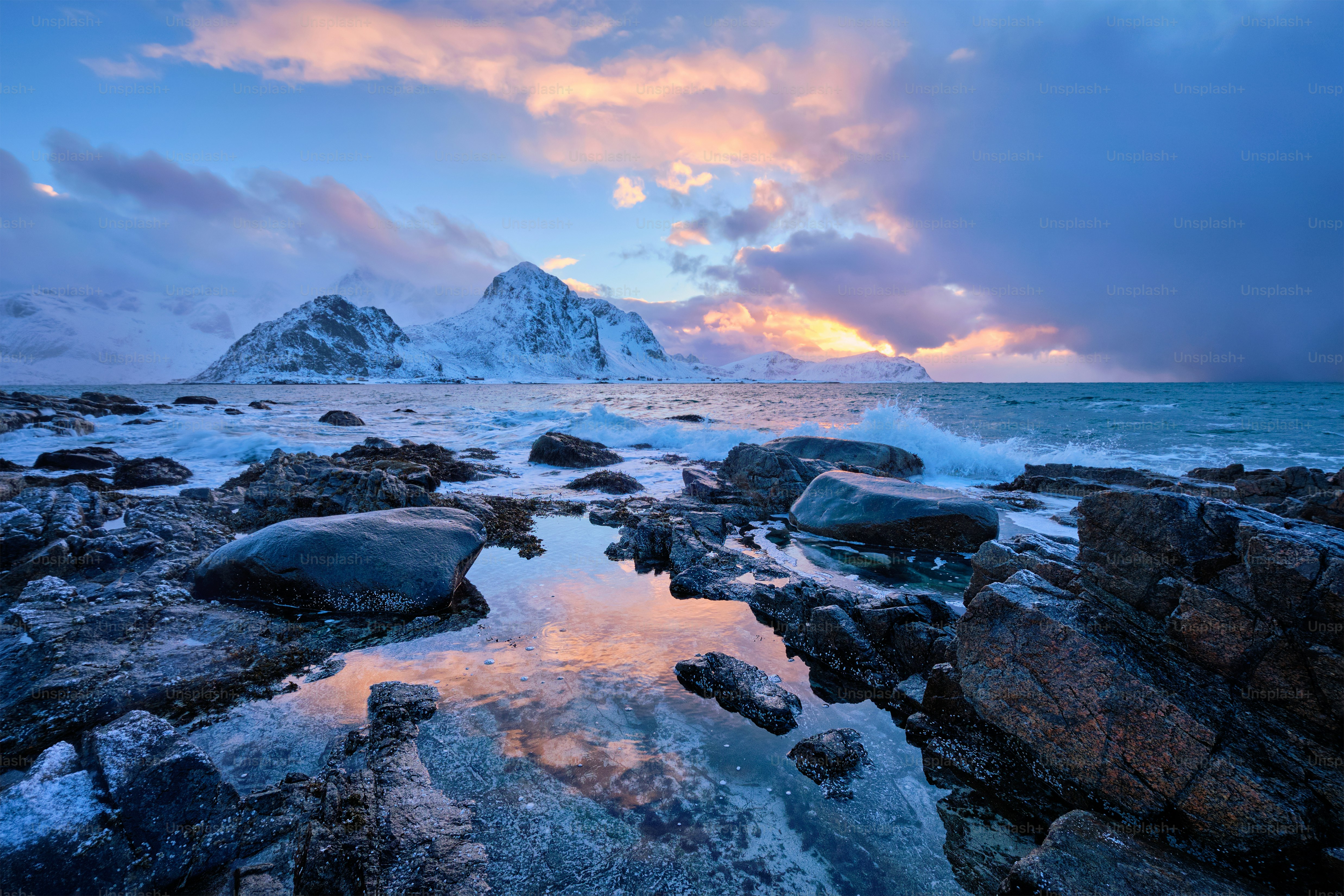 Beach of Norwegian sea on rocky coast in fjord on sunset in winter ...