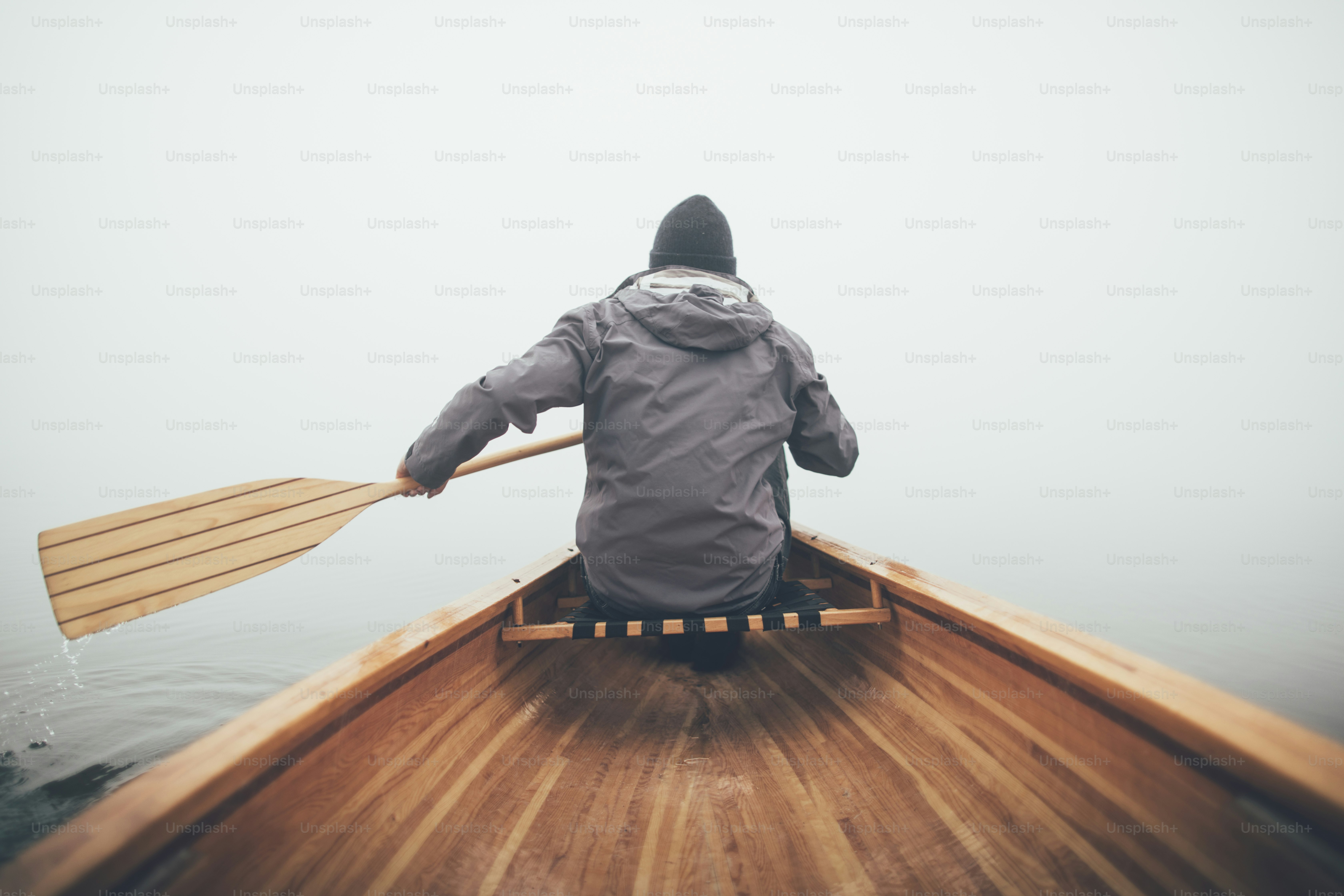 Vista trasera del hombre remando en canoa en la neblina foto – Imagen ...