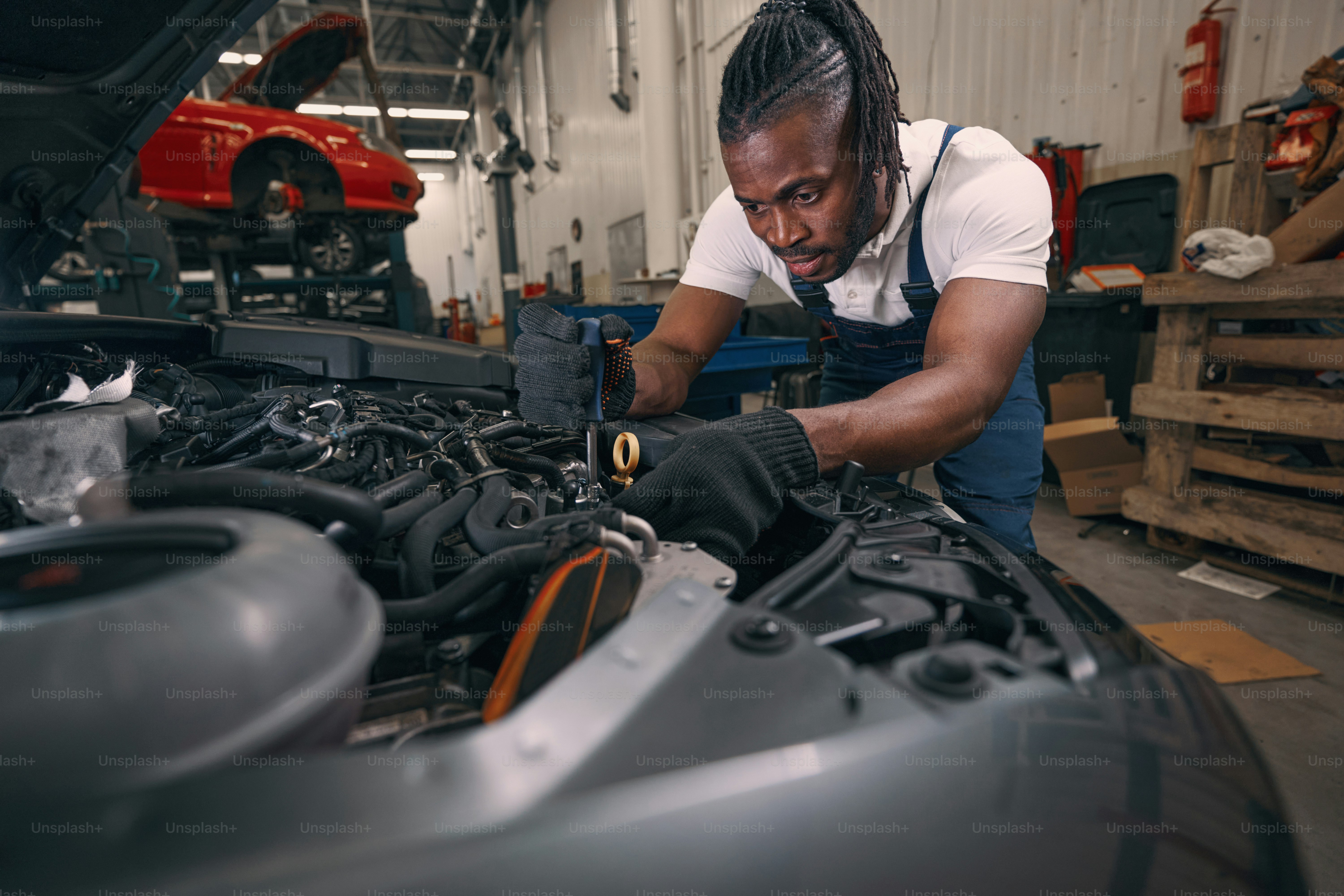 Light vehicle technician working on removing screws inside automobile ...