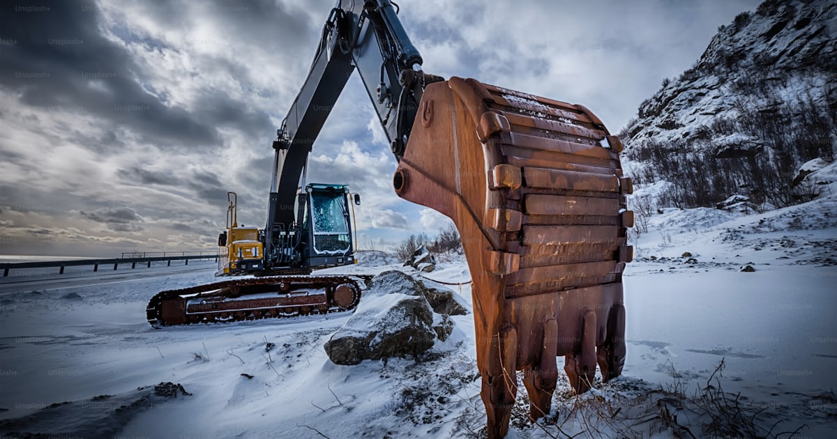 冬の掘削機バケットを備えた古い掘削機。雪の中の道路工事。ノルウェーのロフォーテン諸島。ハイダイナミックレンジhdr画像の写真