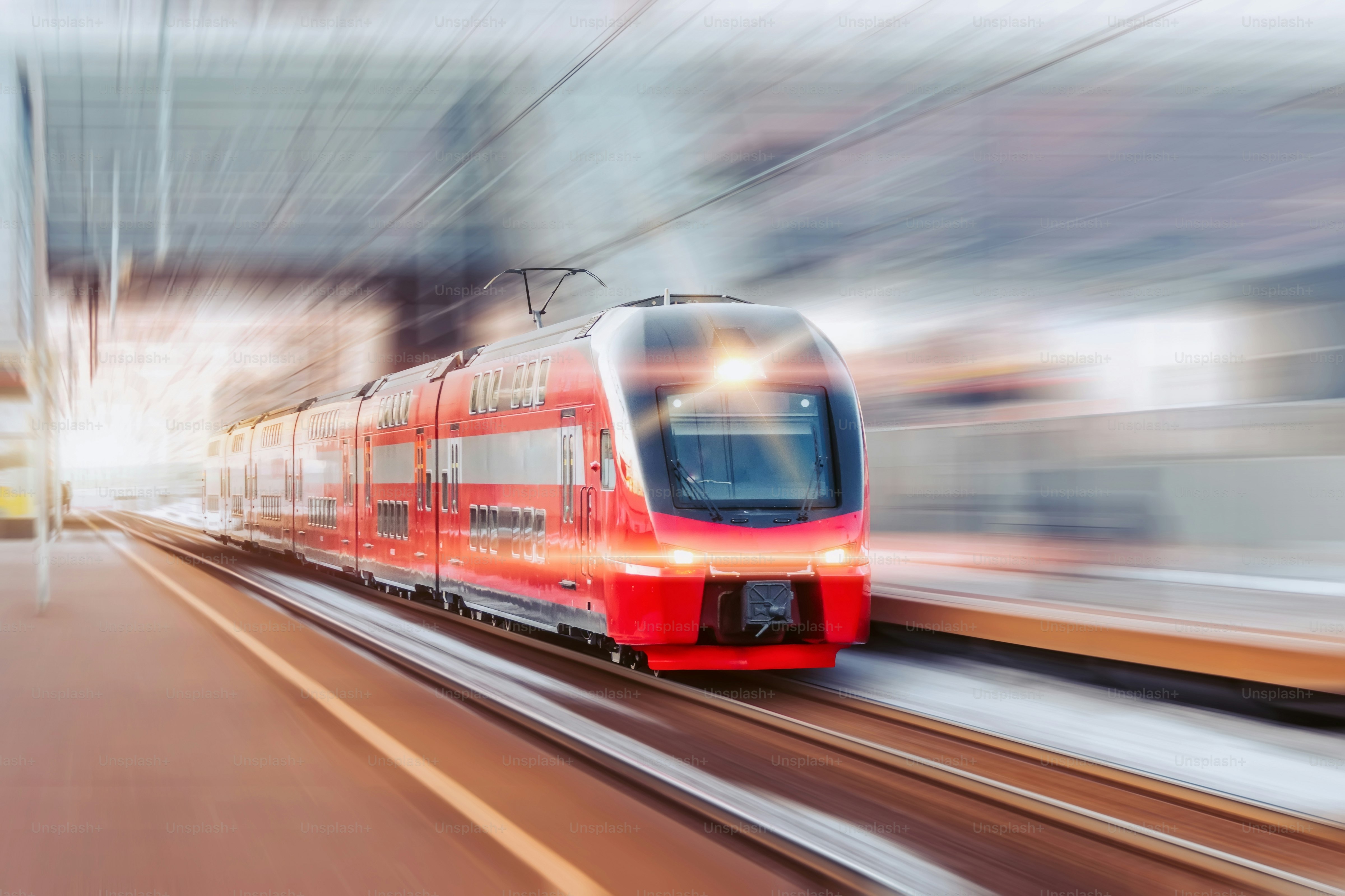 High speed double decker express train arrives at a station in the city ...