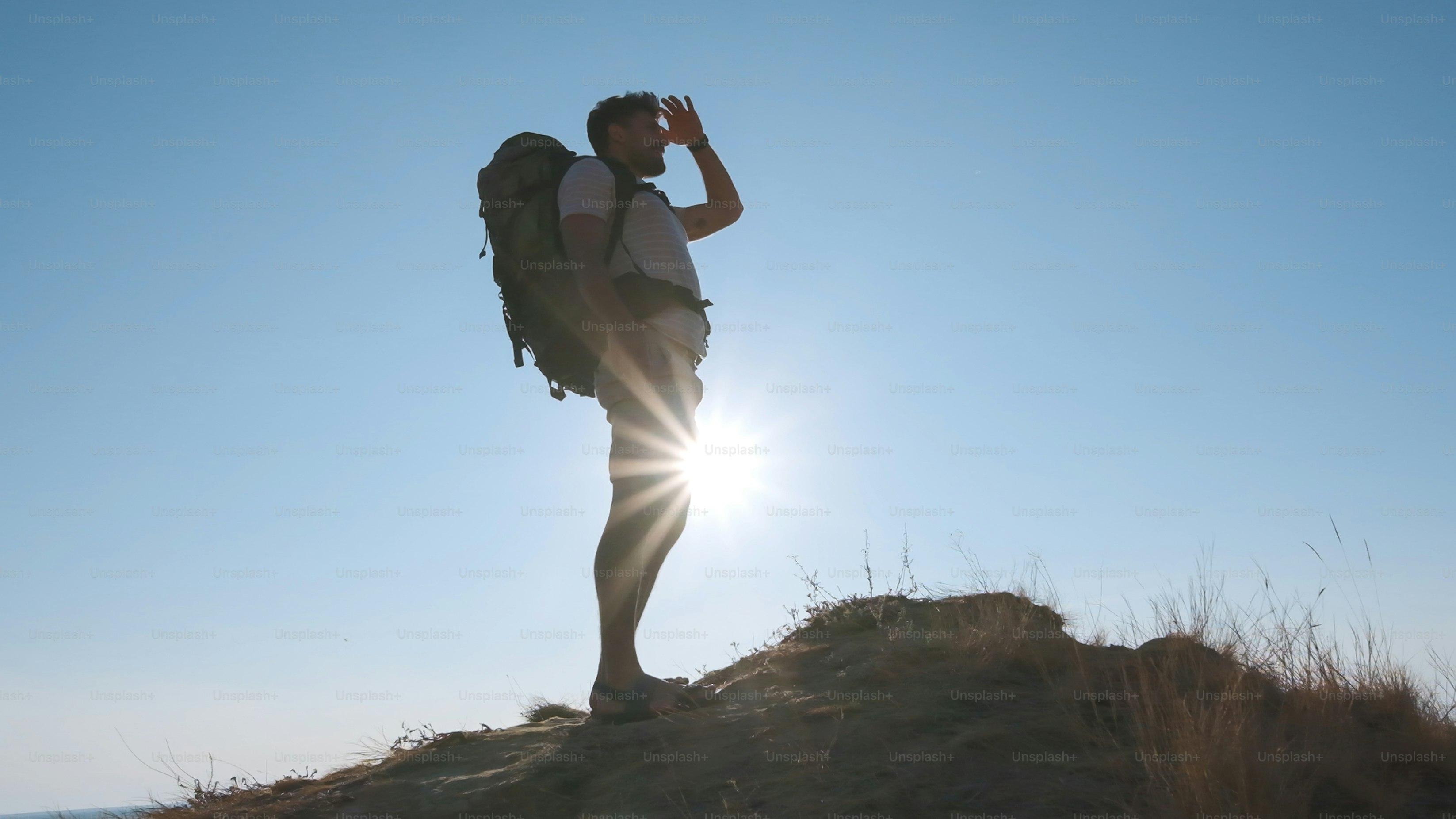 The four travelers with backpacks standing on the mountain top above ...