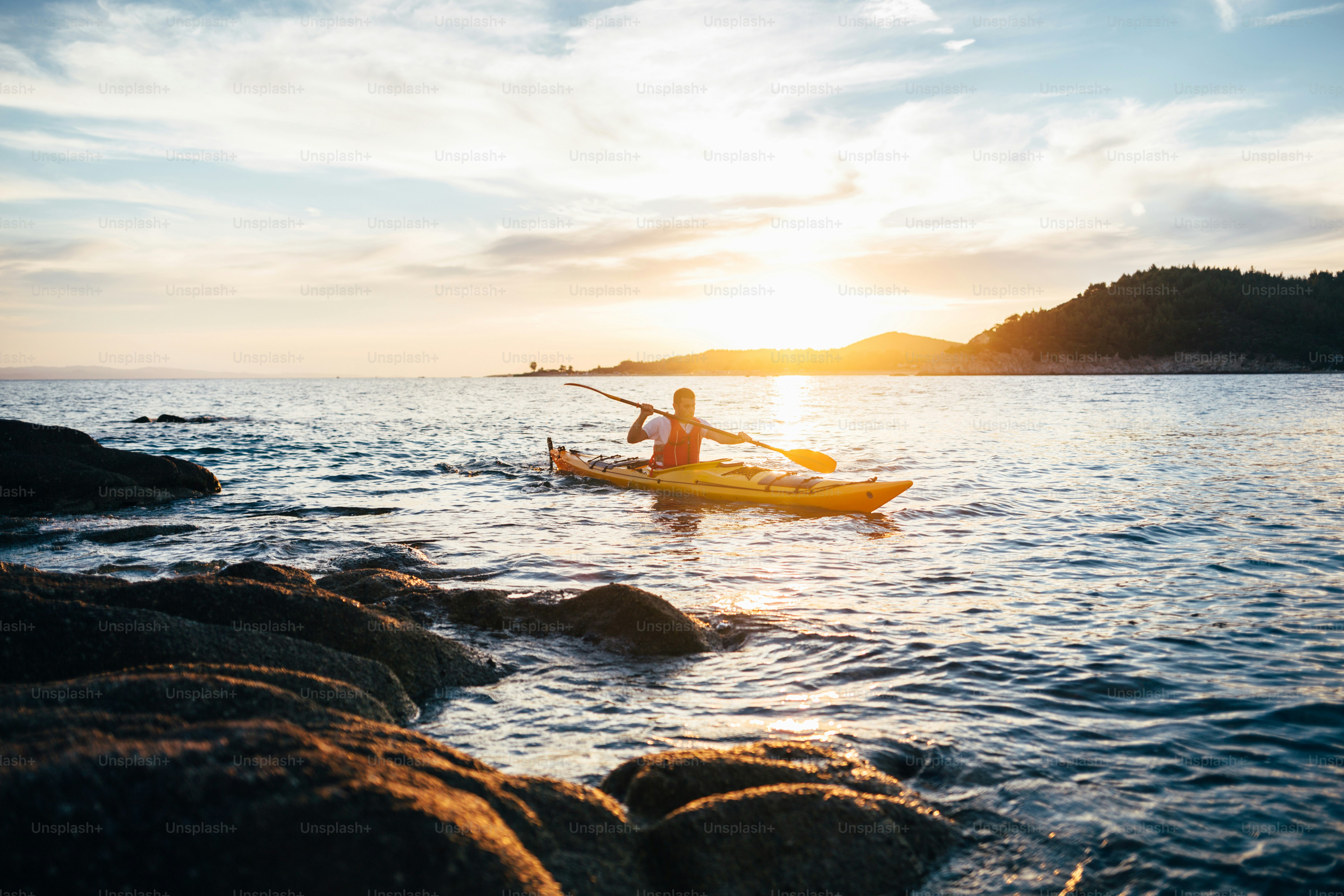 Man kayaker paddling the kayak at sunset sea. photo – Canoeing Image on ...