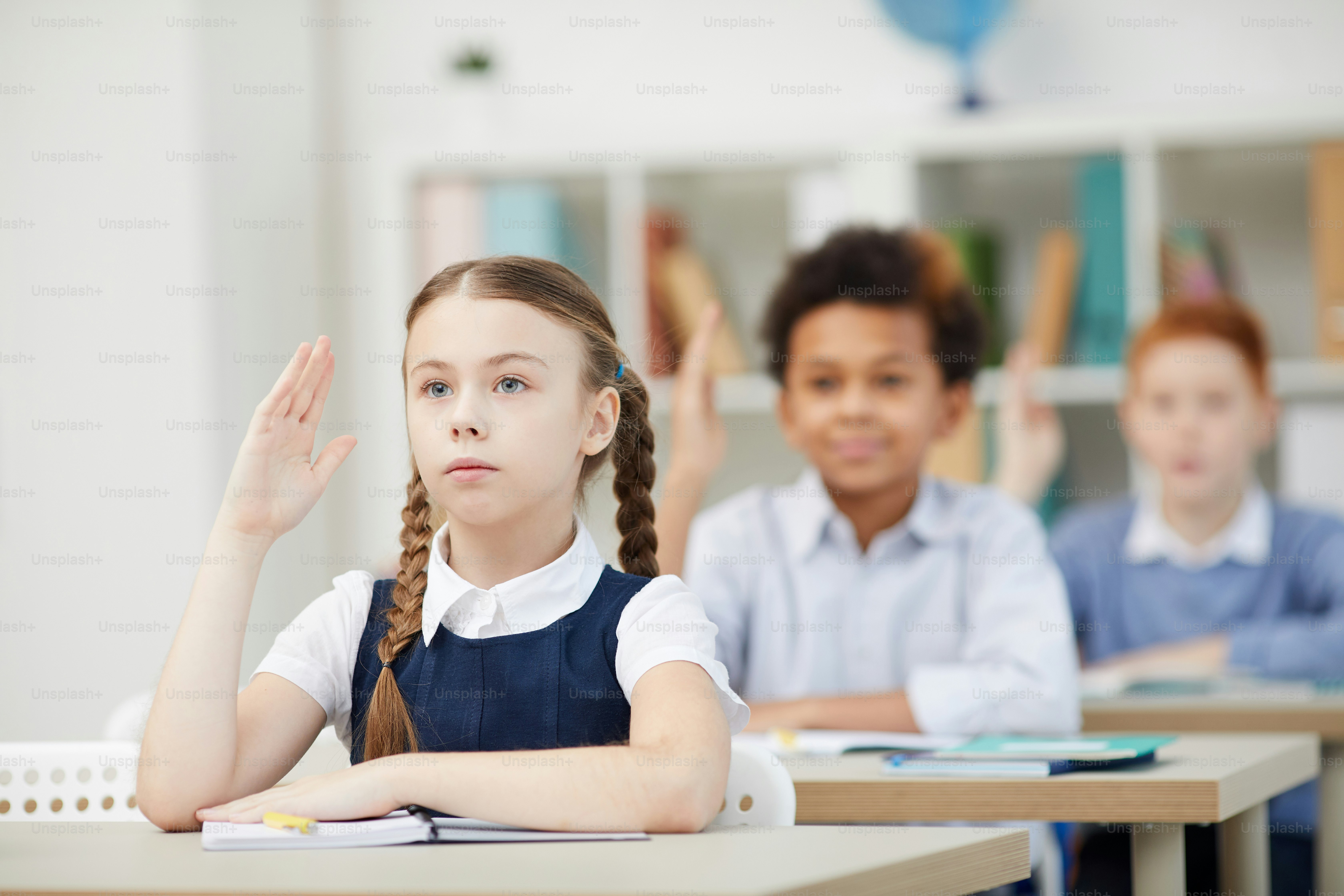 Young teacher in eyeglasses holding clipboard and walking along the ...