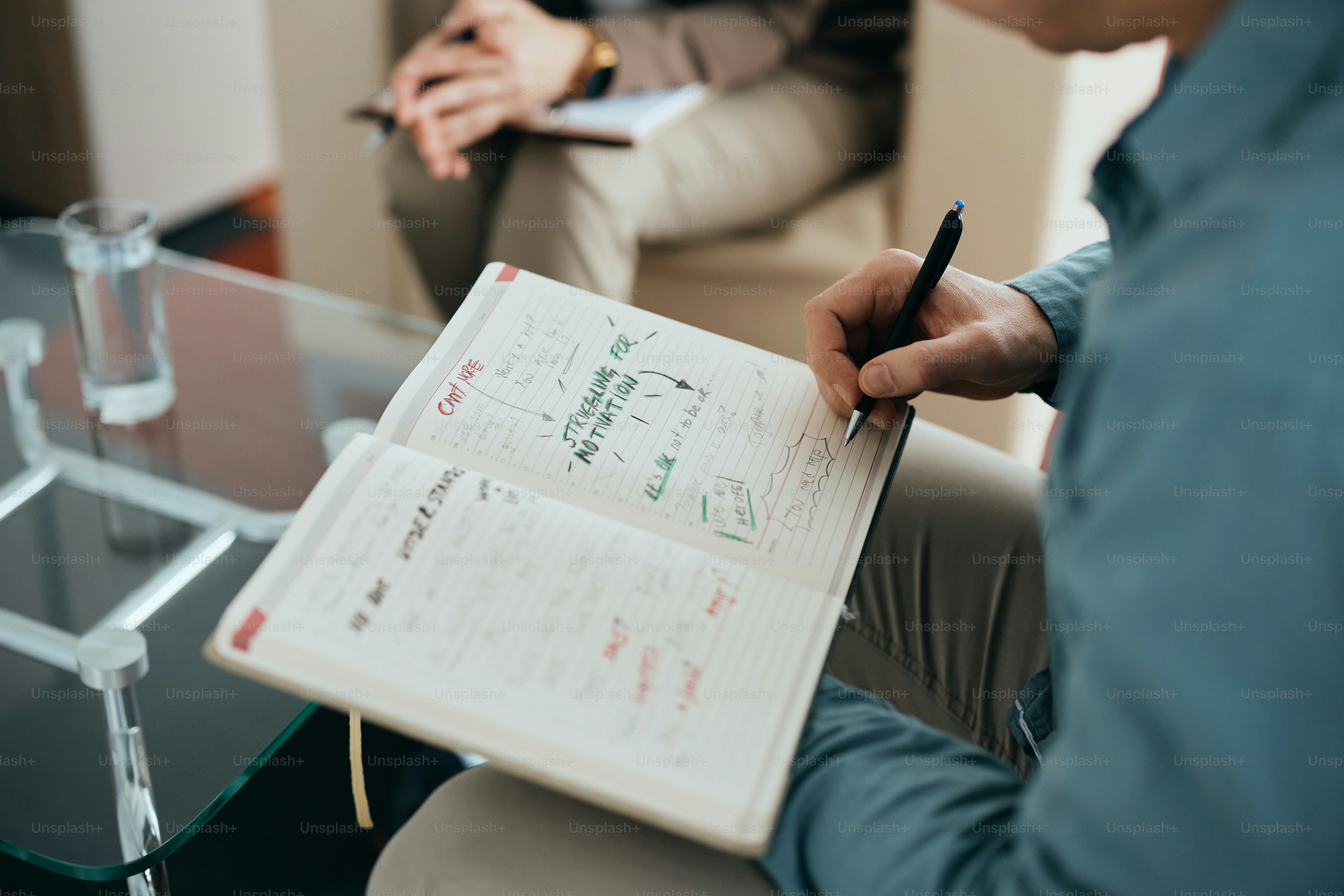 Close-up of male patient writing in notebook while brainstorming during ...