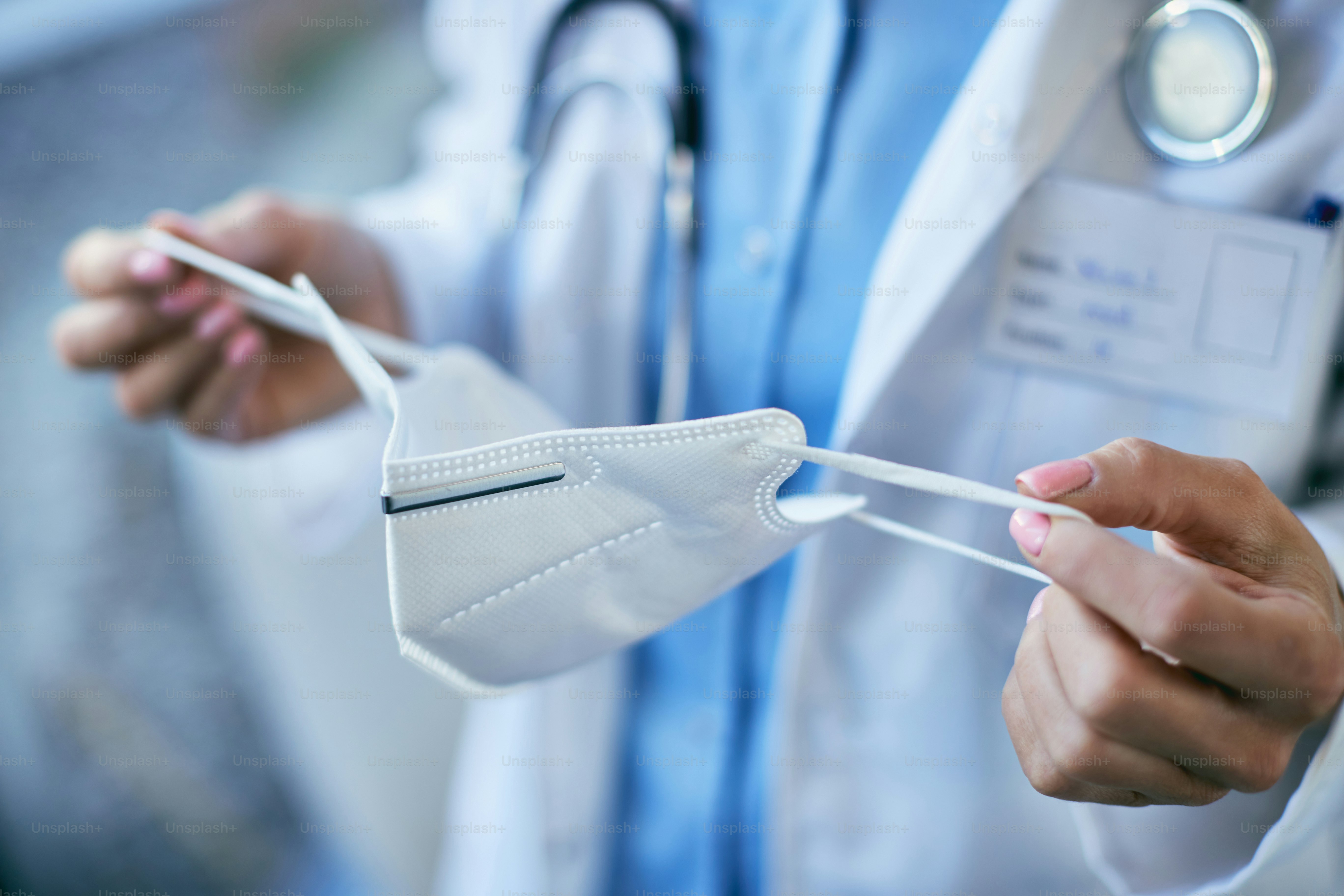 Close-up of doctor using protective face mask at medical clinic due to ...