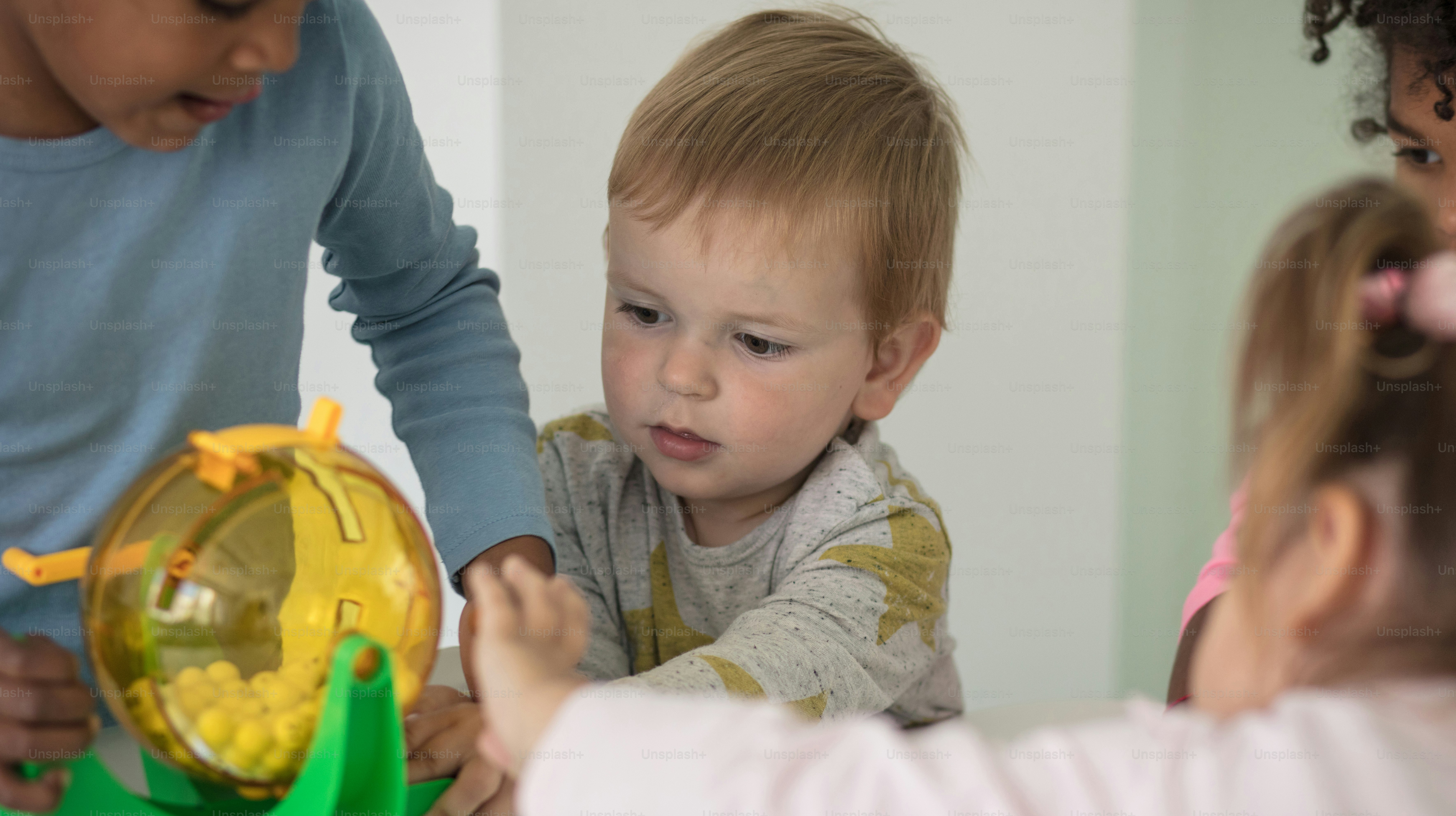 Sharing toy. Children in preschool. photo – Ethnicity Image on Unsplash