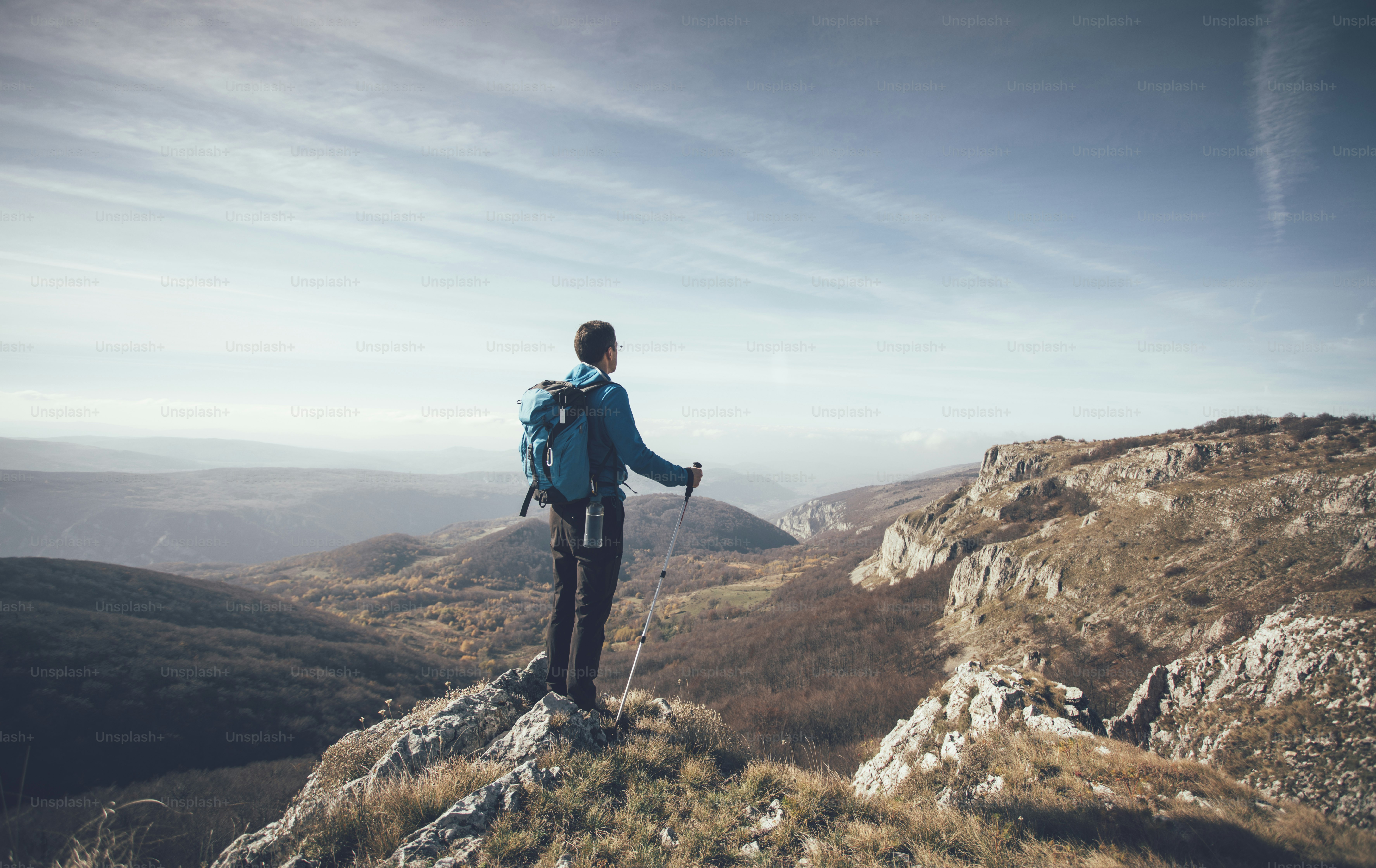 Rear view of hiker man standing at mountain viewpoint. photo ...
