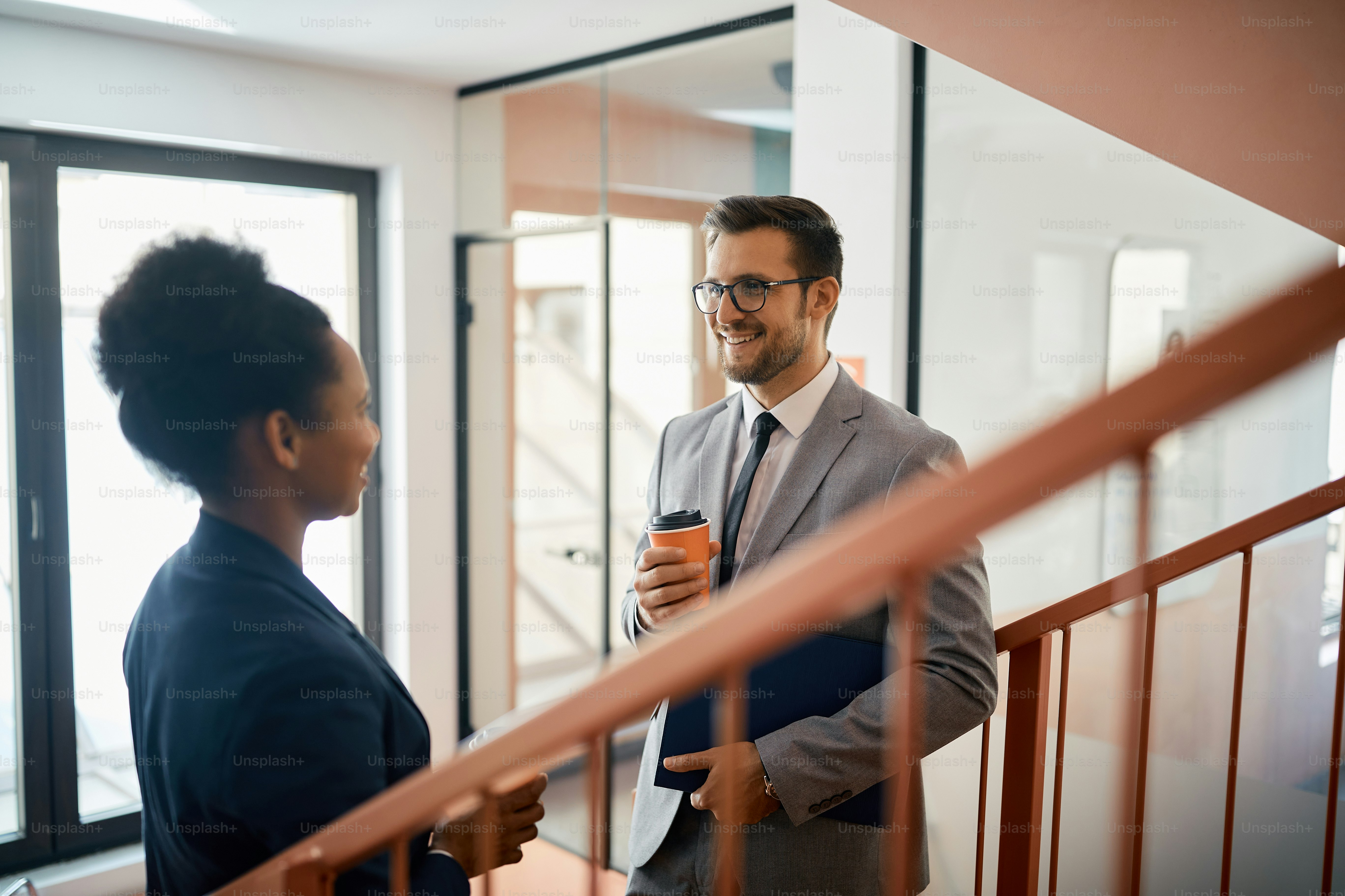 Happy entrepreneur enjoying in conversation with African American ...