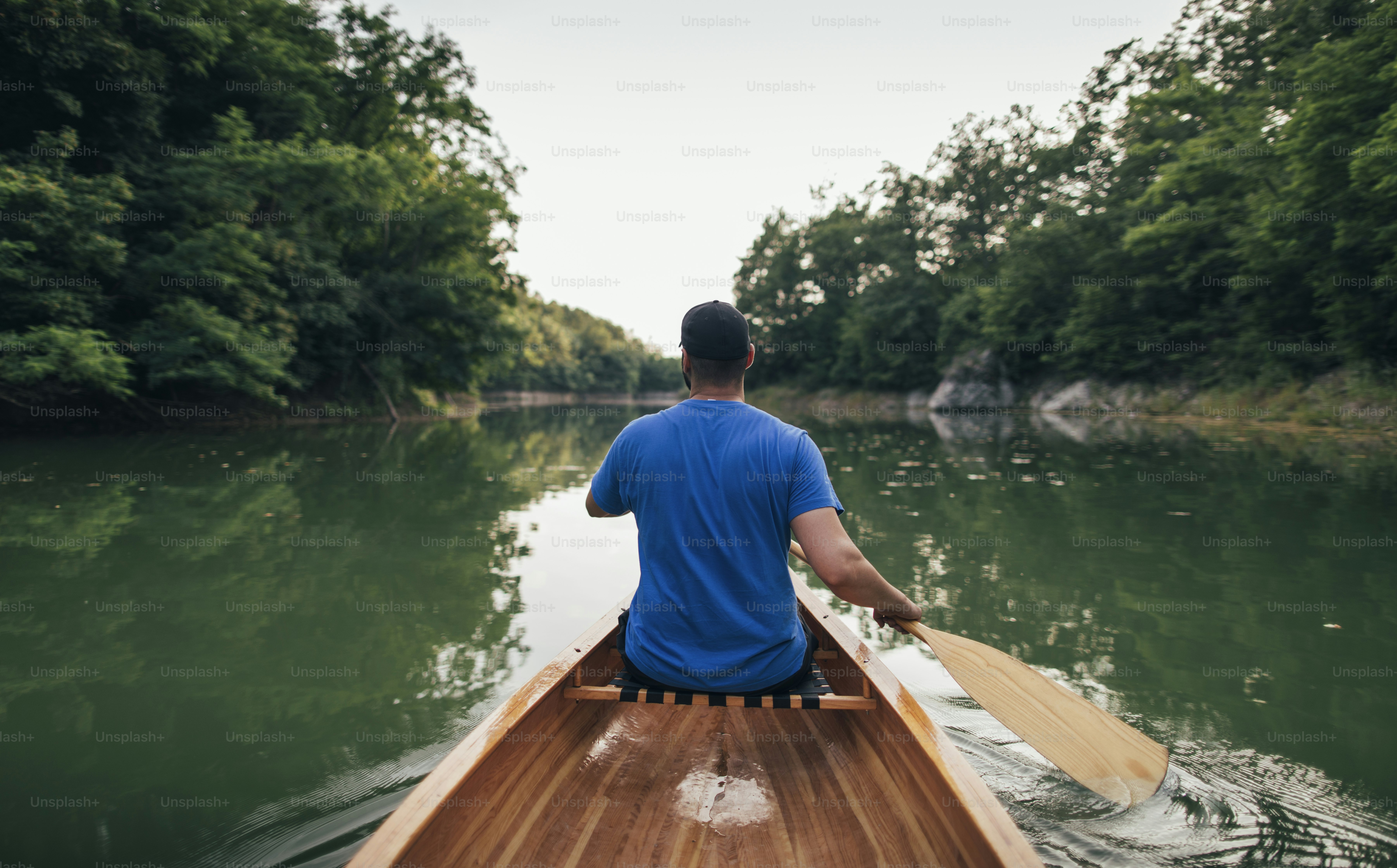 Foto Vista trasera del hombre remando en canoa en el bosque del lago ...