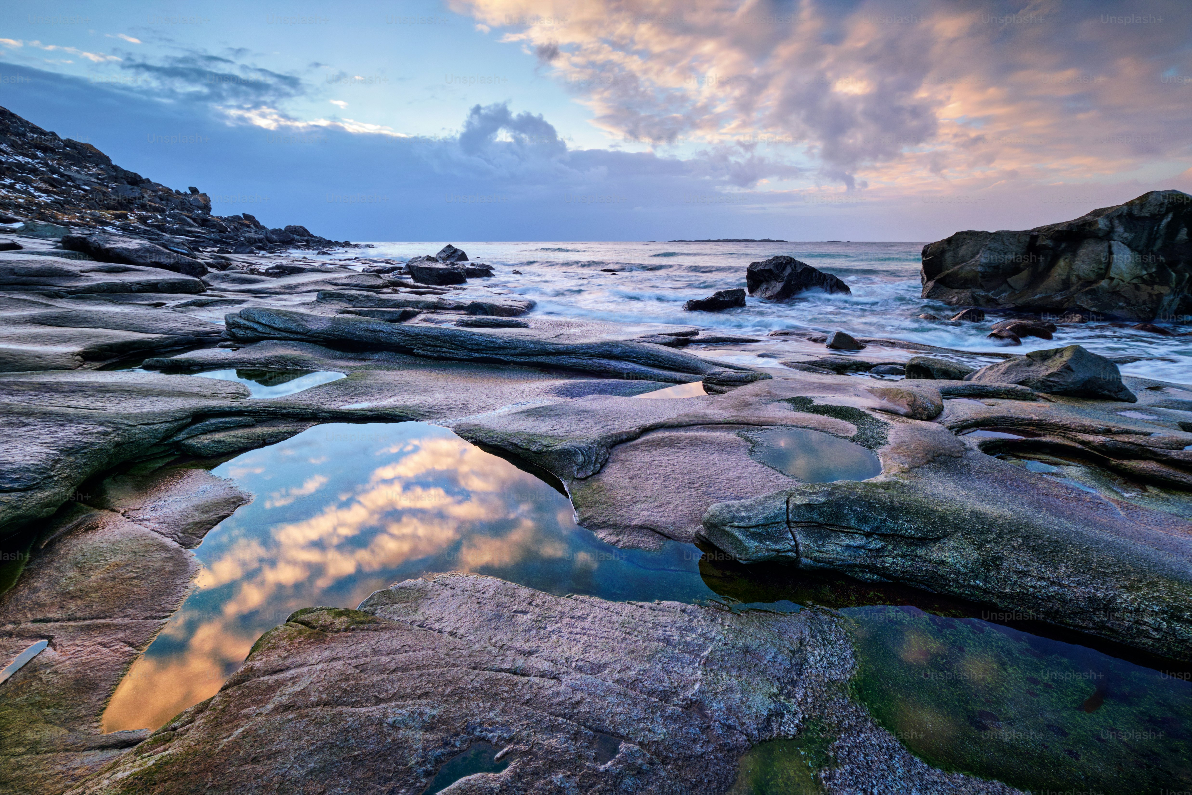 Rocks on beach of fjord of Norwegian sea in winteron sunset. Utakliev ...