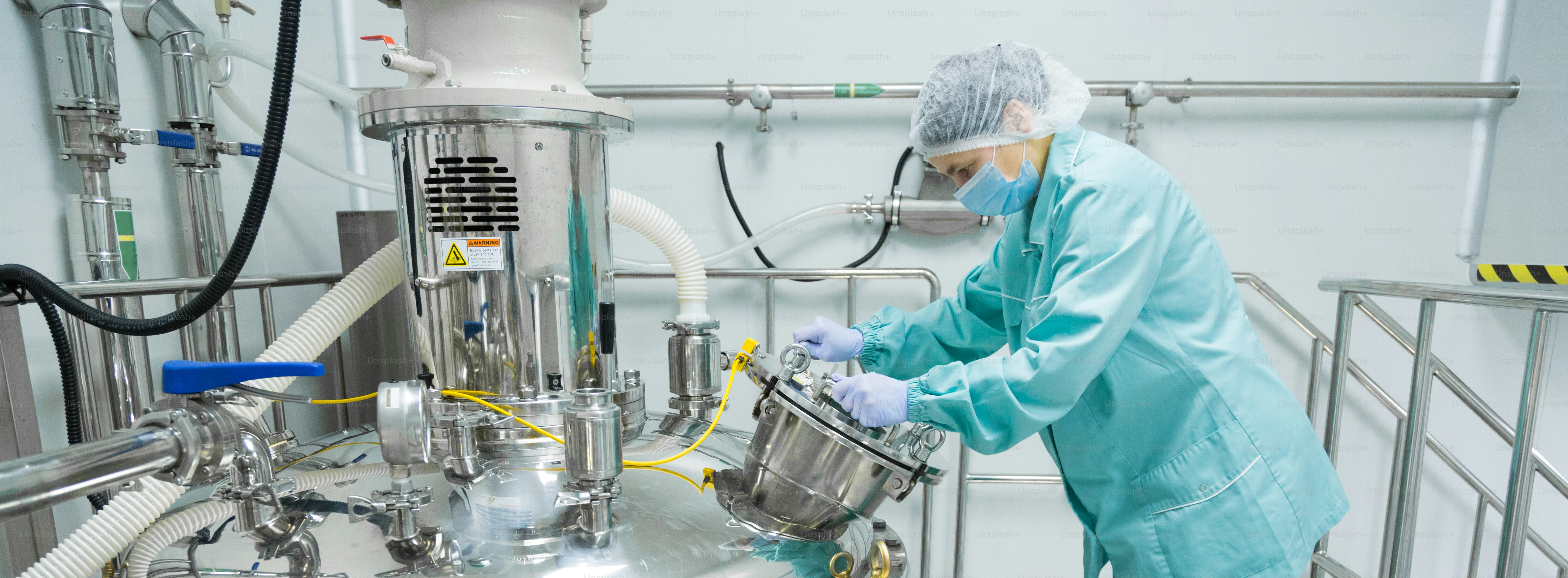 Pharmaceutical technician in sterile environment working with equipment ...