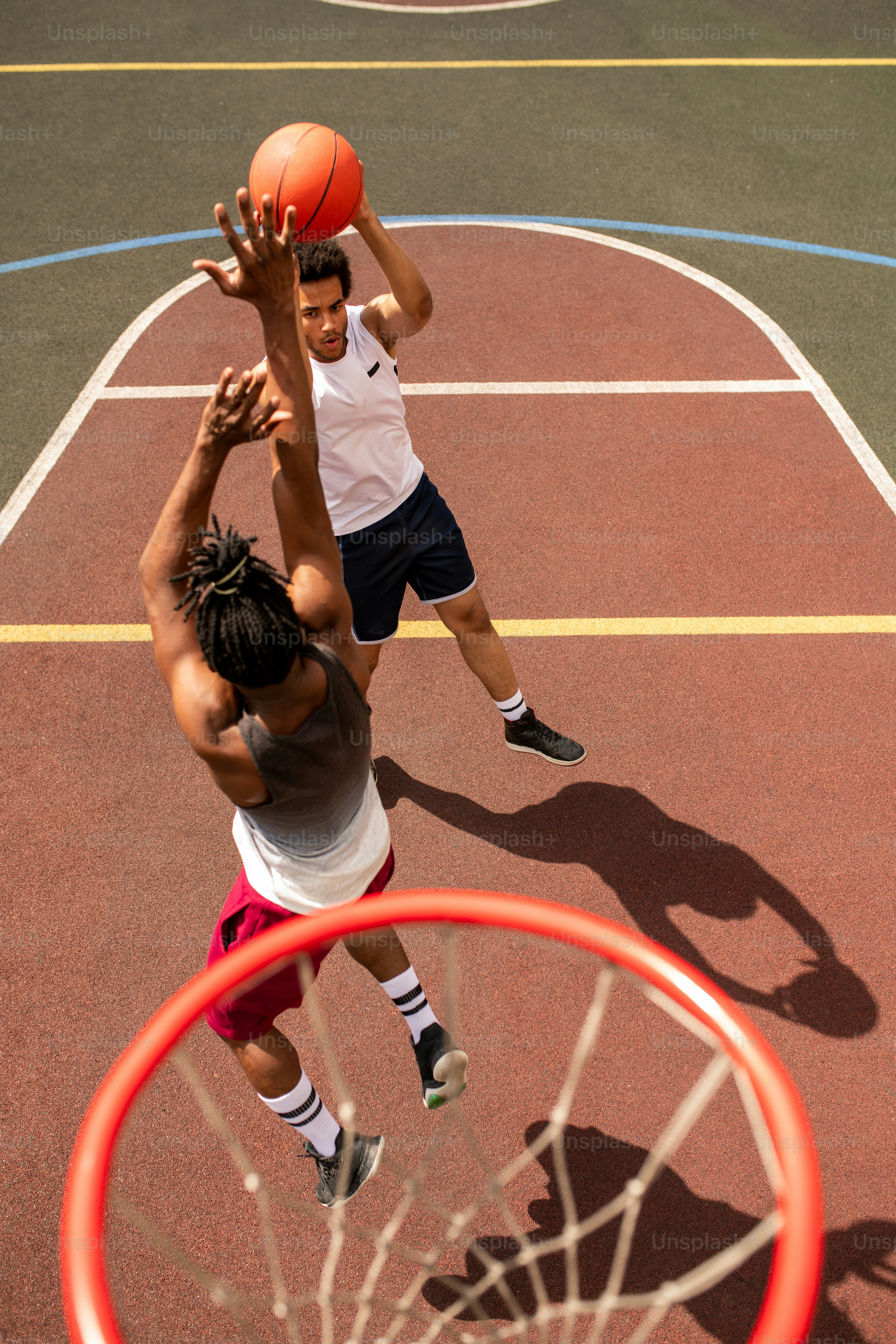 One of young intercultural basketball players attacking the ball while ...