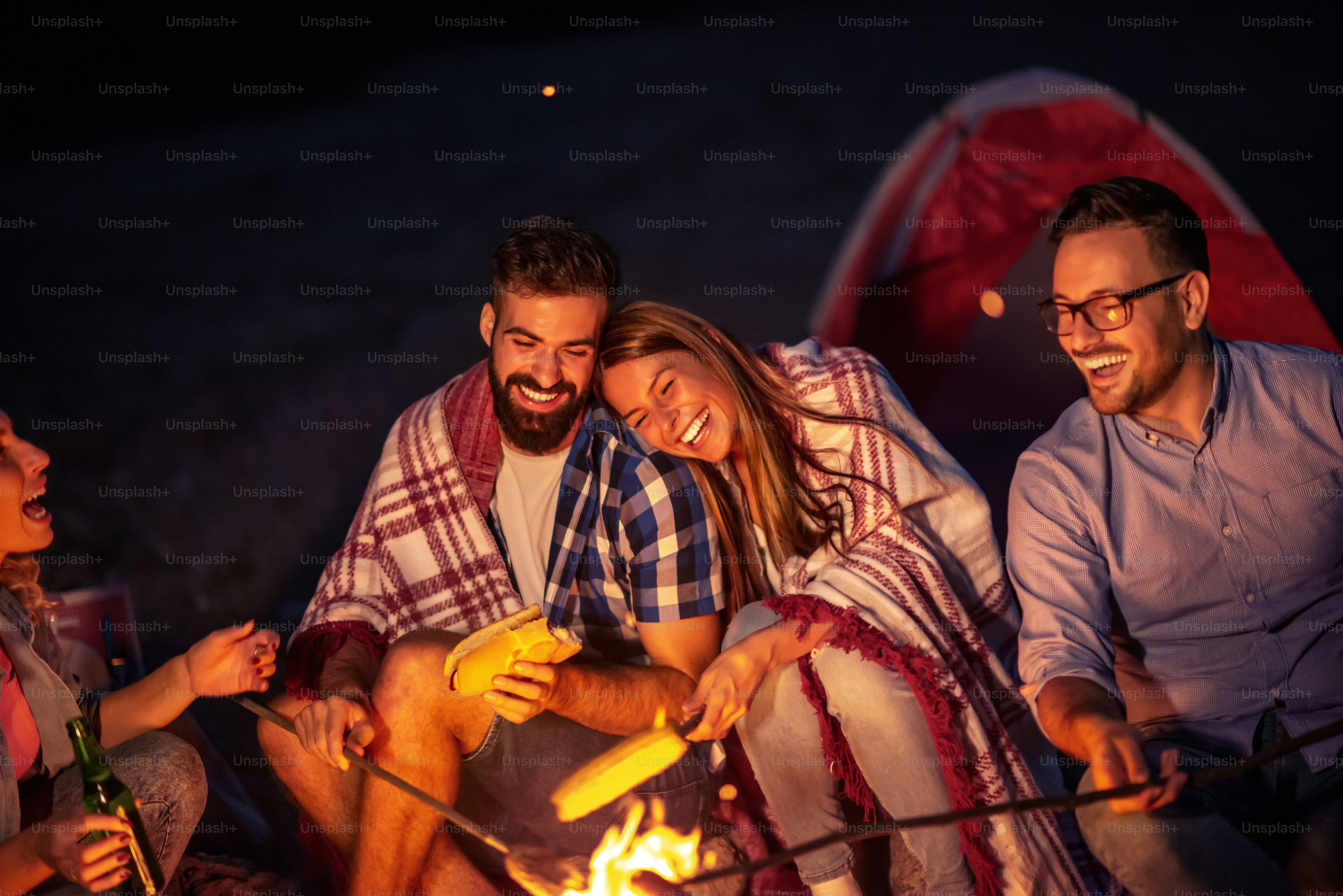 Friends having picnic around the fire.Group of young friends having ...