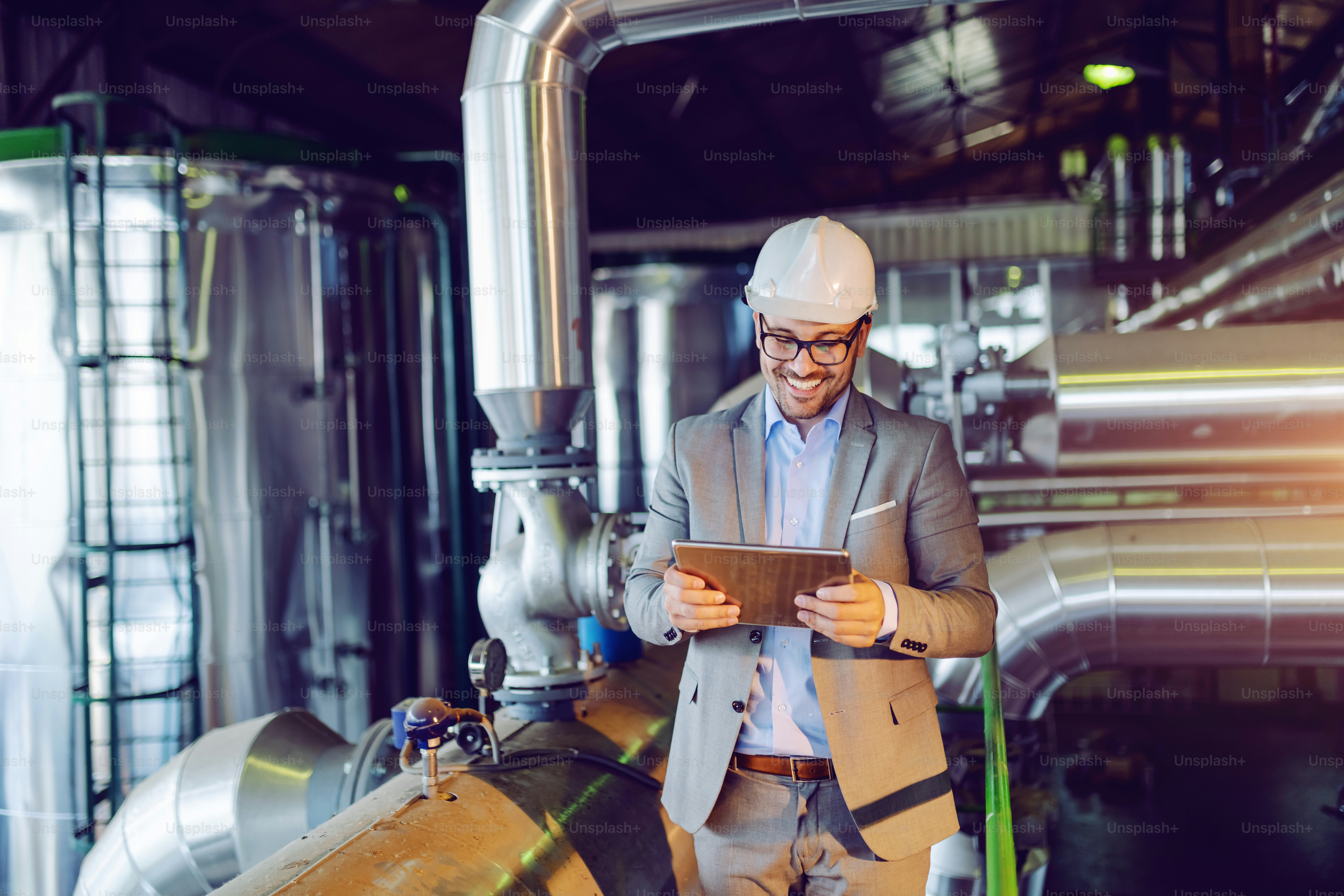 Handsome smiling caucasian supervisor in suit and with helmet on head ...