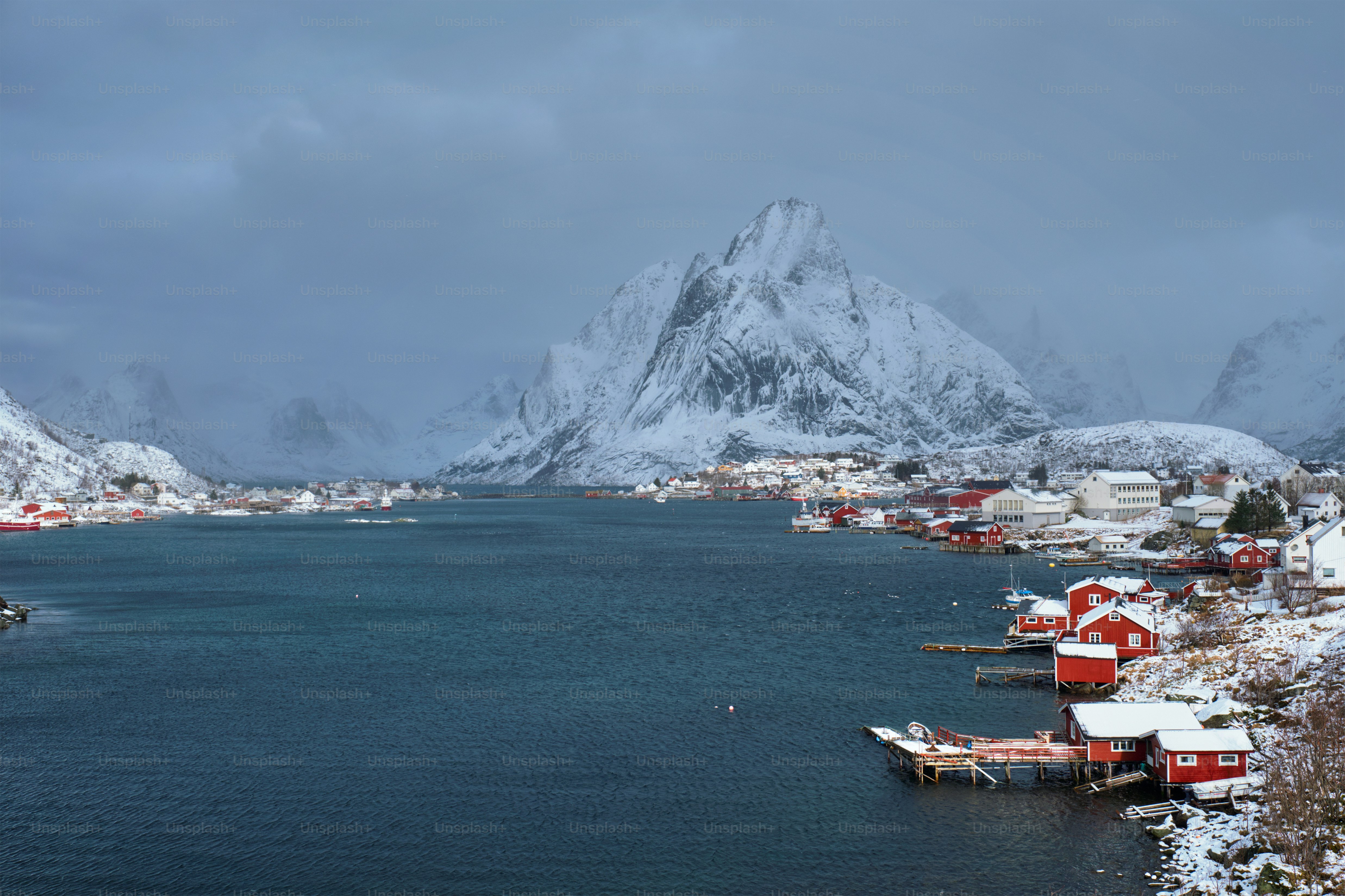 Yellow rorbu houses of Sakrisoy fishing village with snow in winter ...