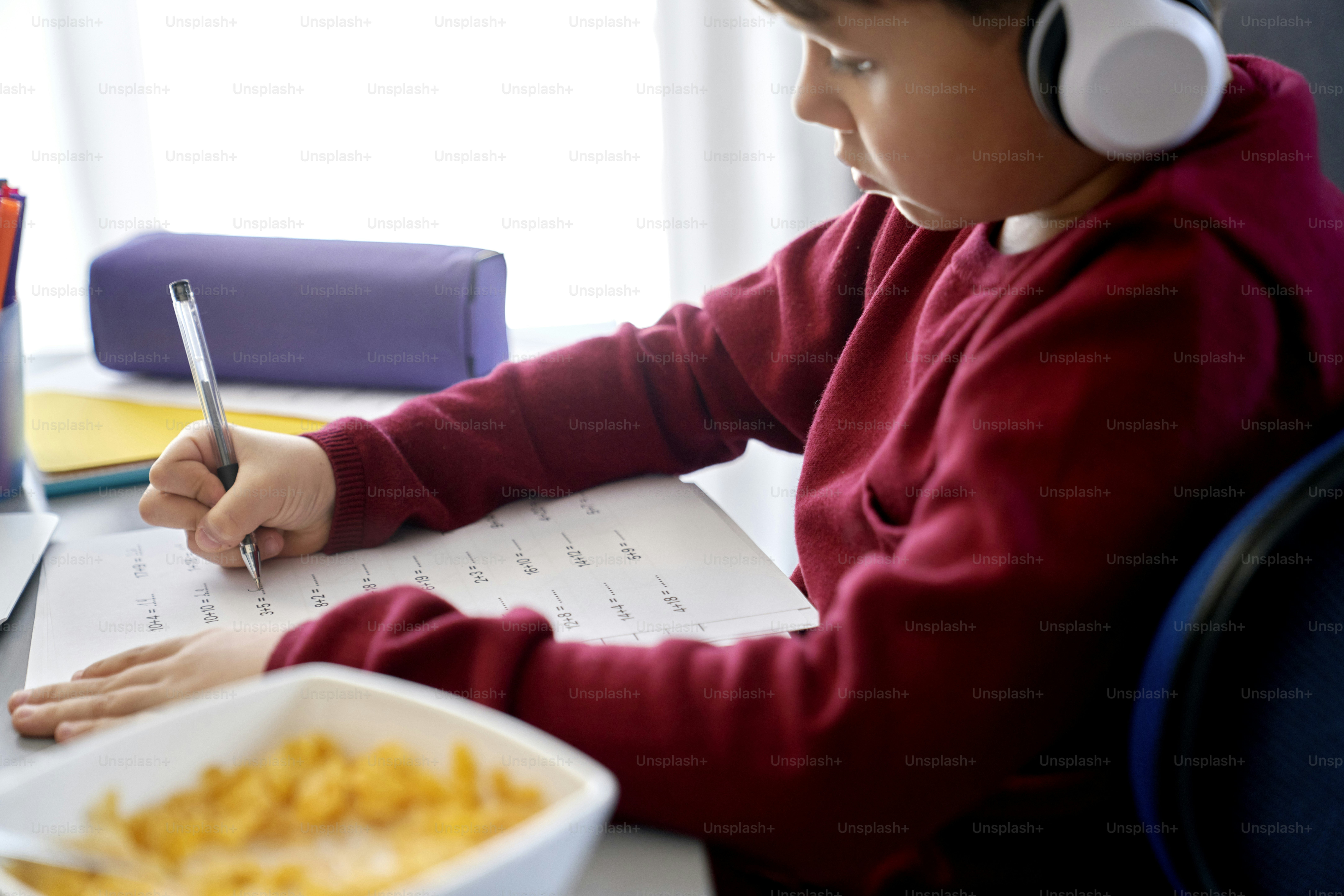 Close up side view of boy doing math homework photo – Calculating Image ...