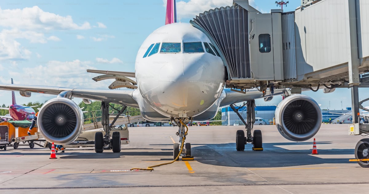 공항 주차장에 있는 상업용 여객기는 기수가 앞으로 있고 통로가 있습니다 비행 서비스 및 준비 사진 Unsplash의 공항 이미지