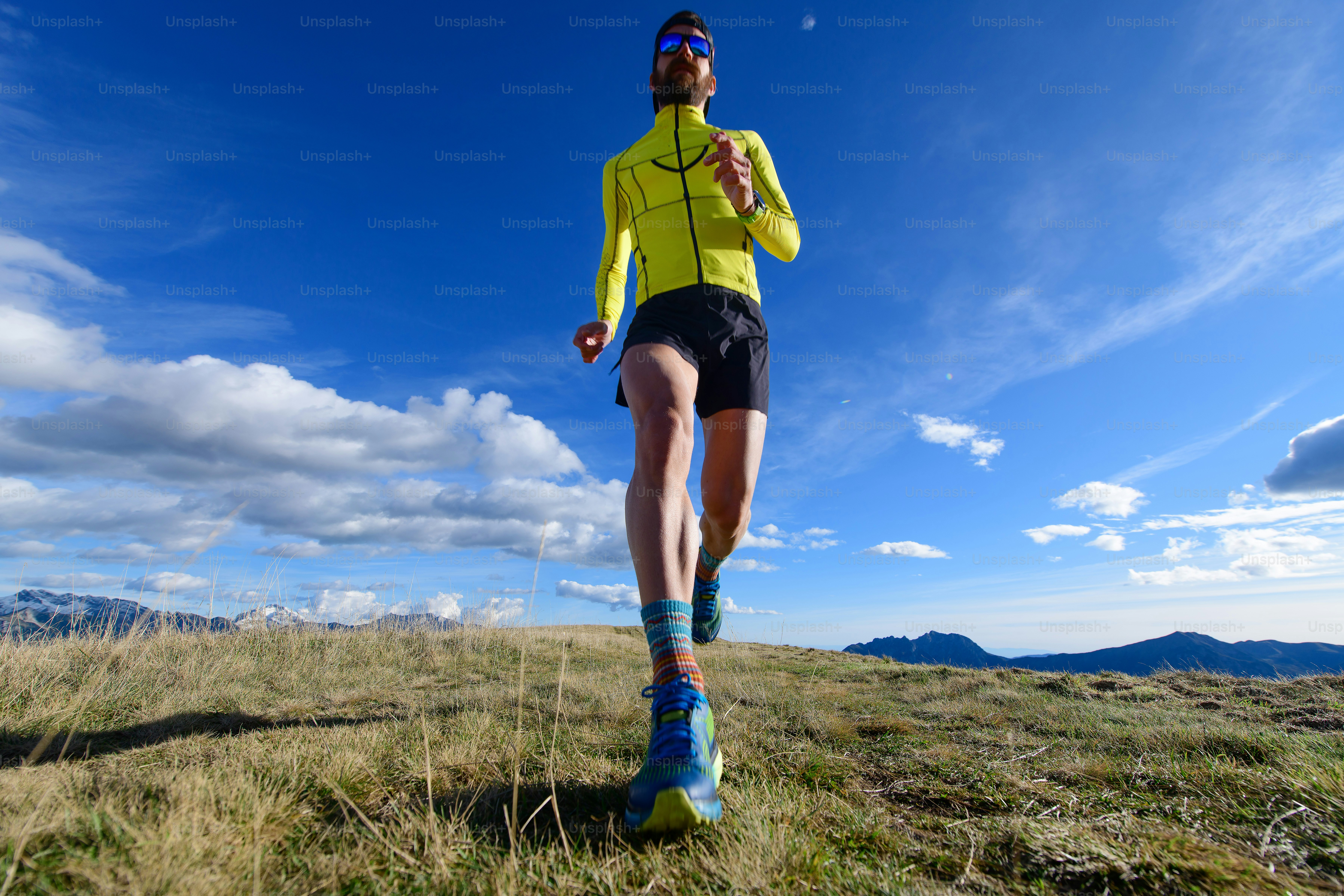Mountain runner in a meadow trains for a marathon photo – Trail run ...