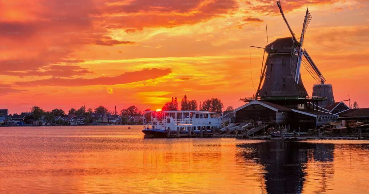 オランダの田園風景 オランダの有名な観光地ザーンセ・スカンスの風車と、劇的な空を持つ夕日。ザーンダム オランダの写真 オランダ