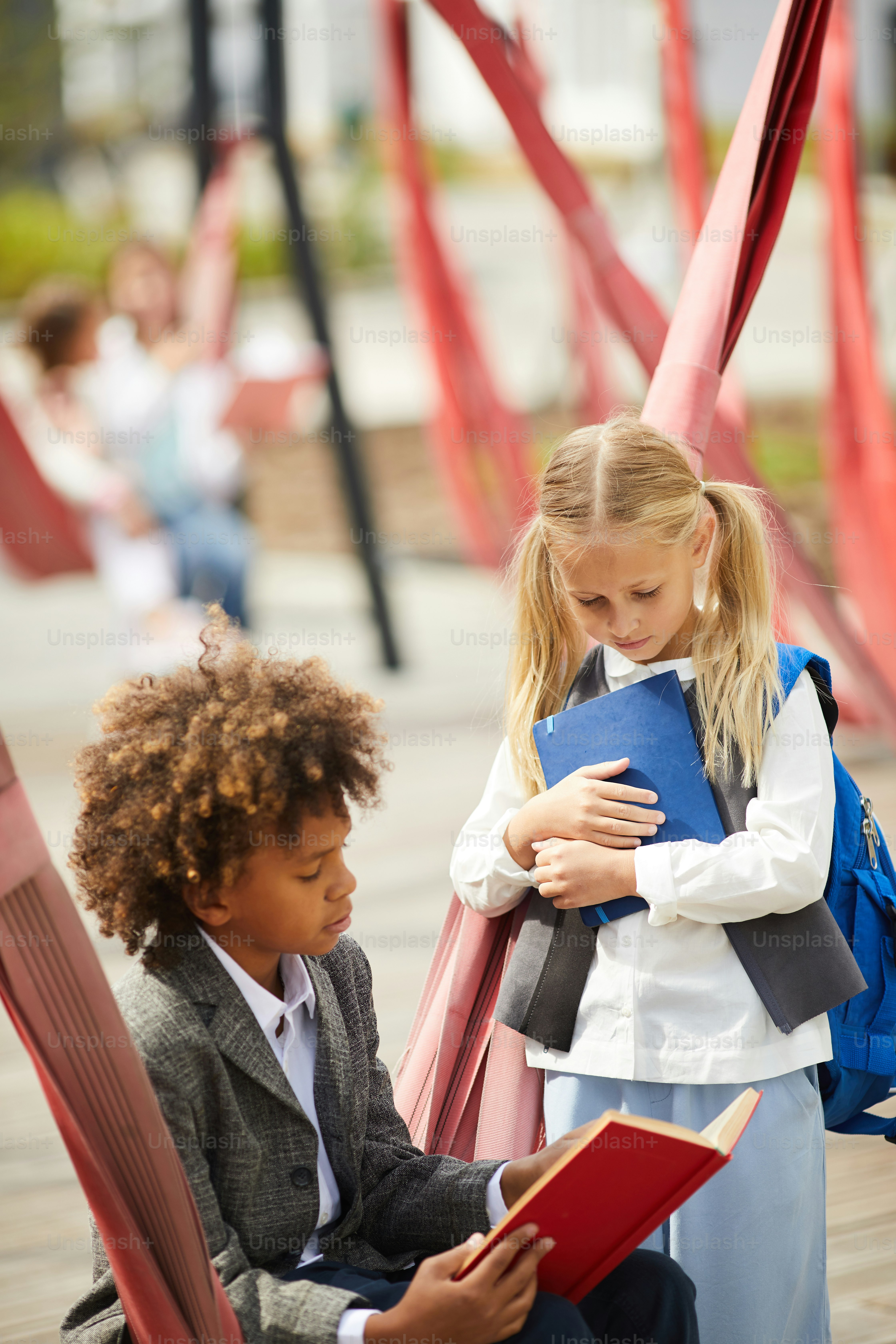 Two school classmates reading book and working together in team while ...