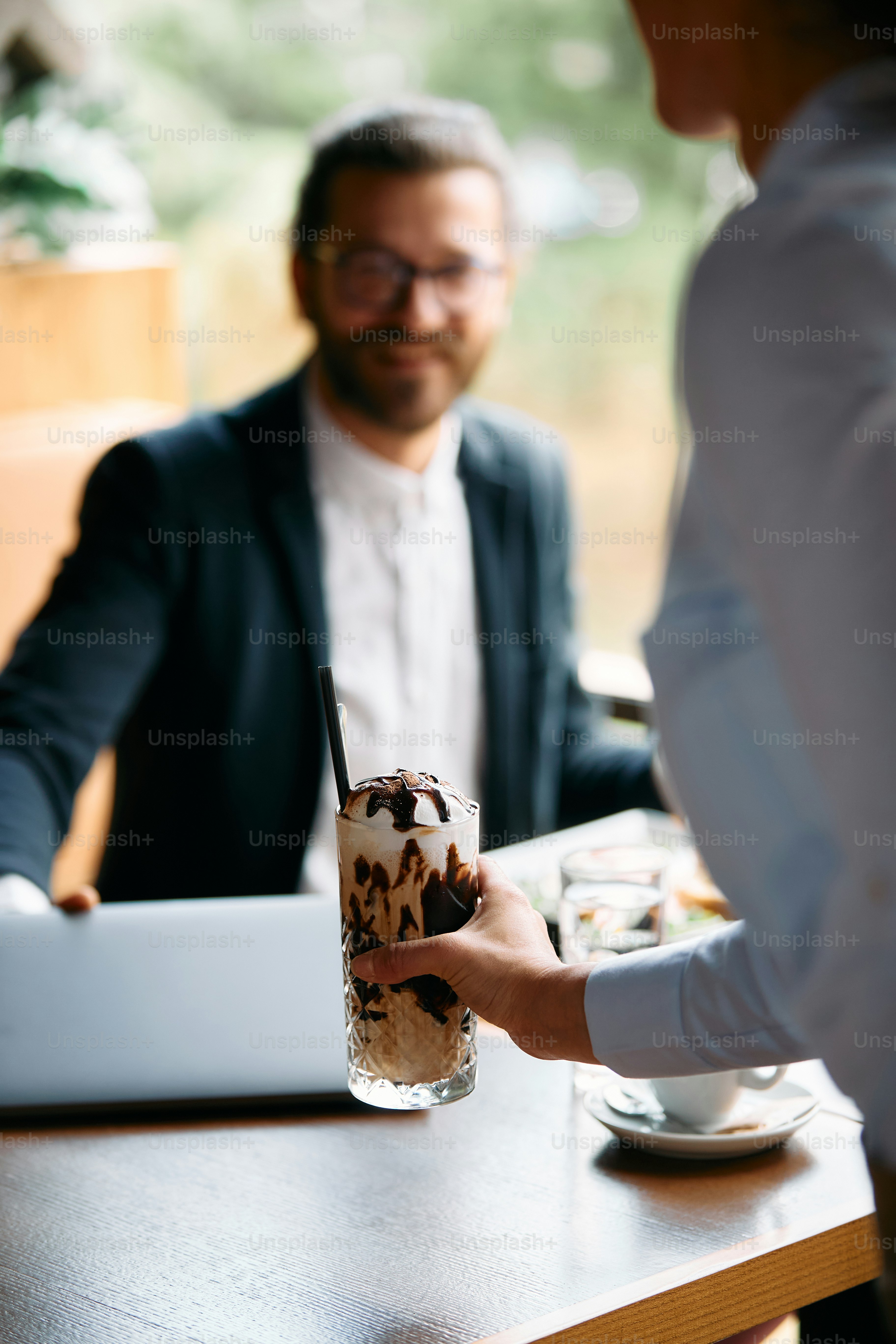 Close-up of waitress bringing chocolate mocha with whipped cream to a ...