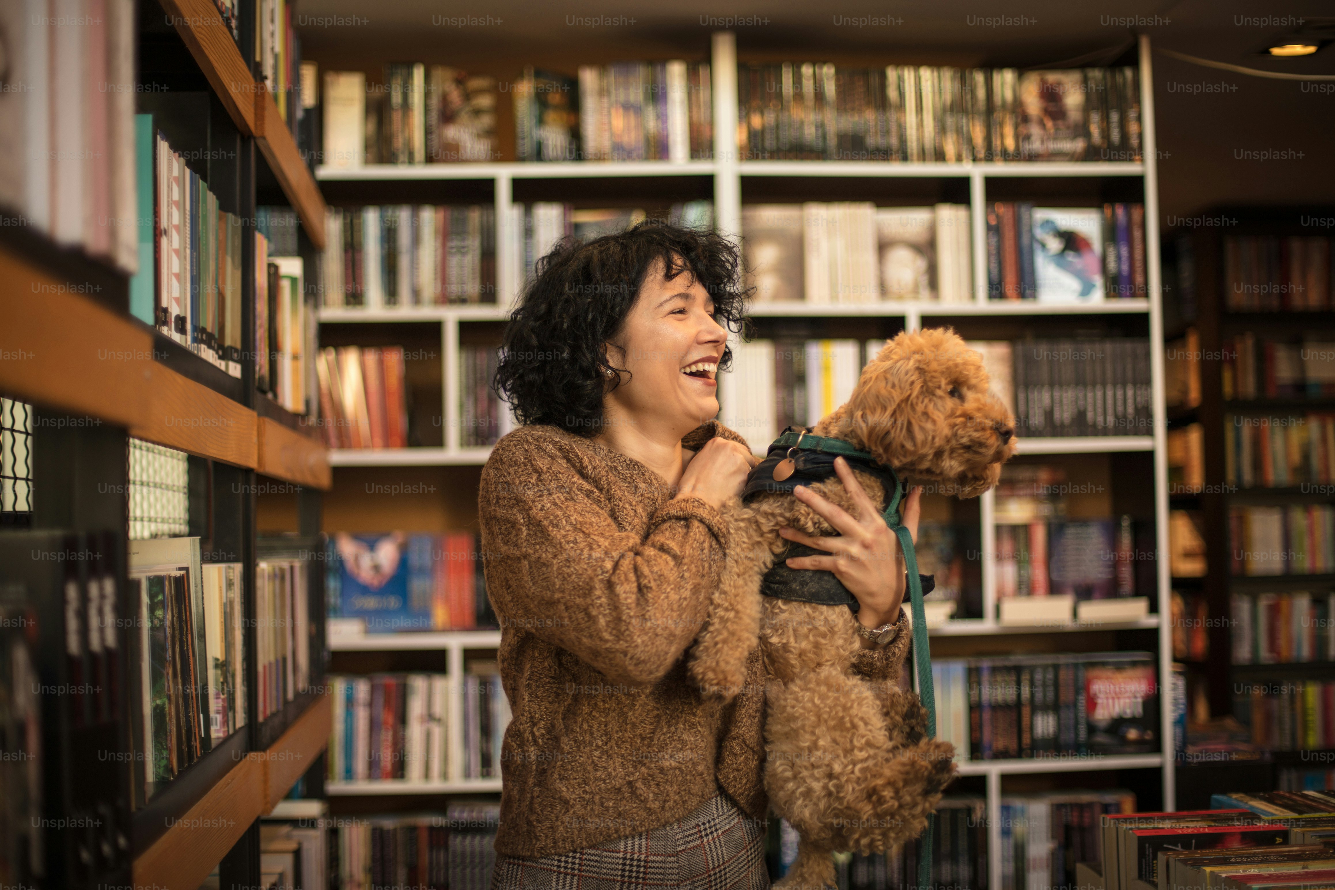 Happy woman with her dog in library. photo – Indoors Image on Unsplash