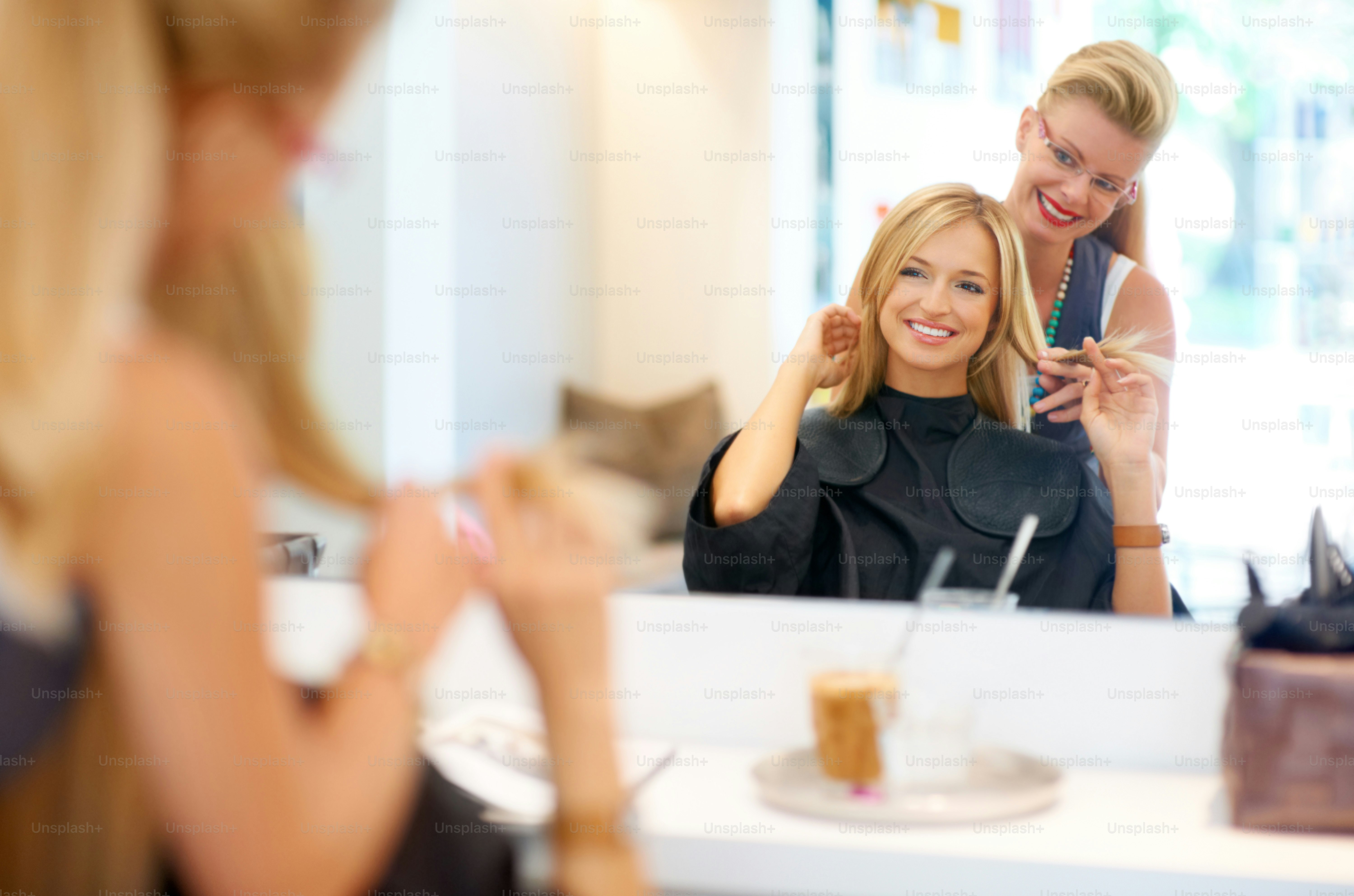 Young woman smiling while having a consultation with her hair stylist ...